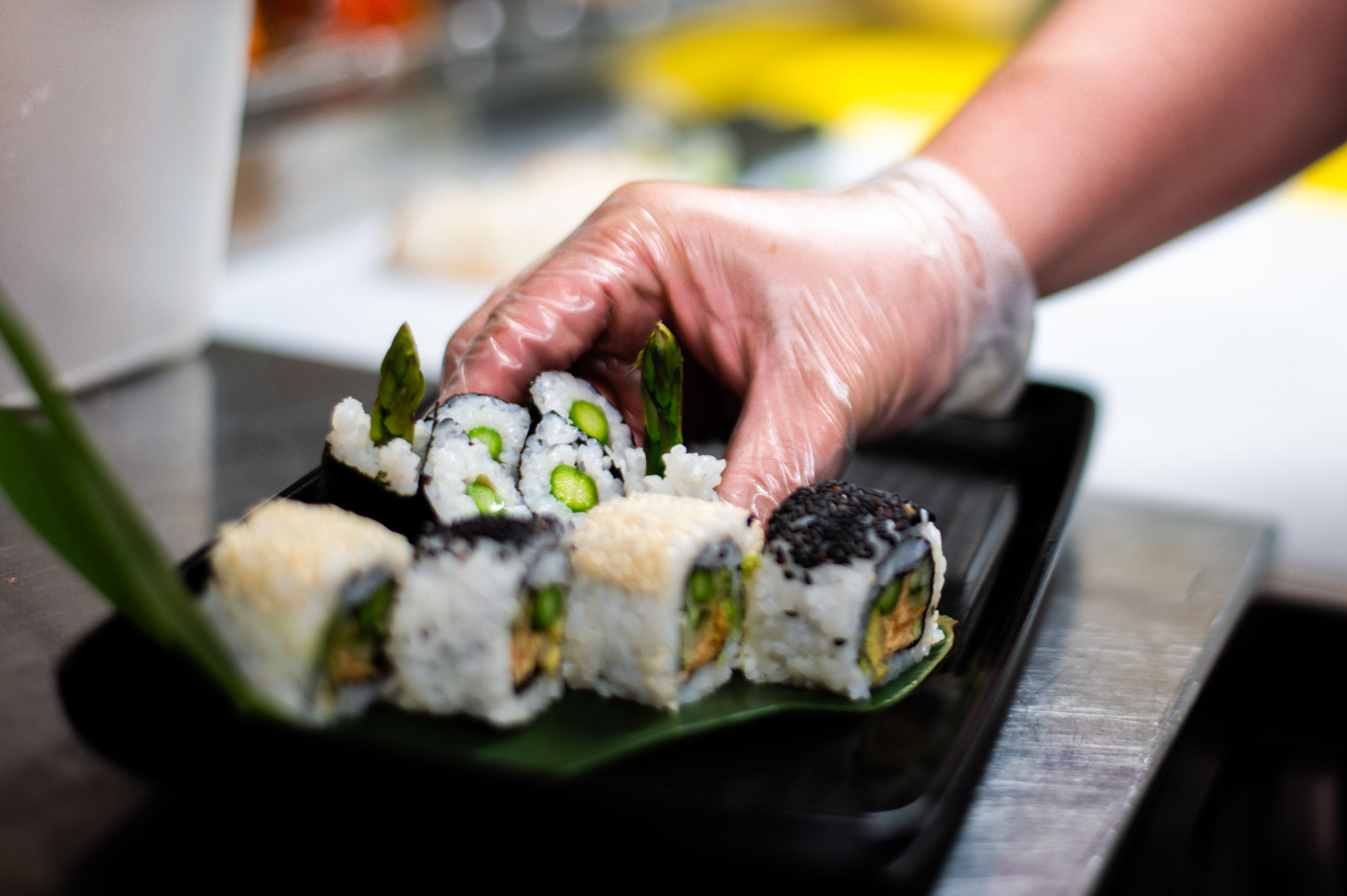 Close-Up of Hand Preparing Sushi Rolls · Free Stock Photo