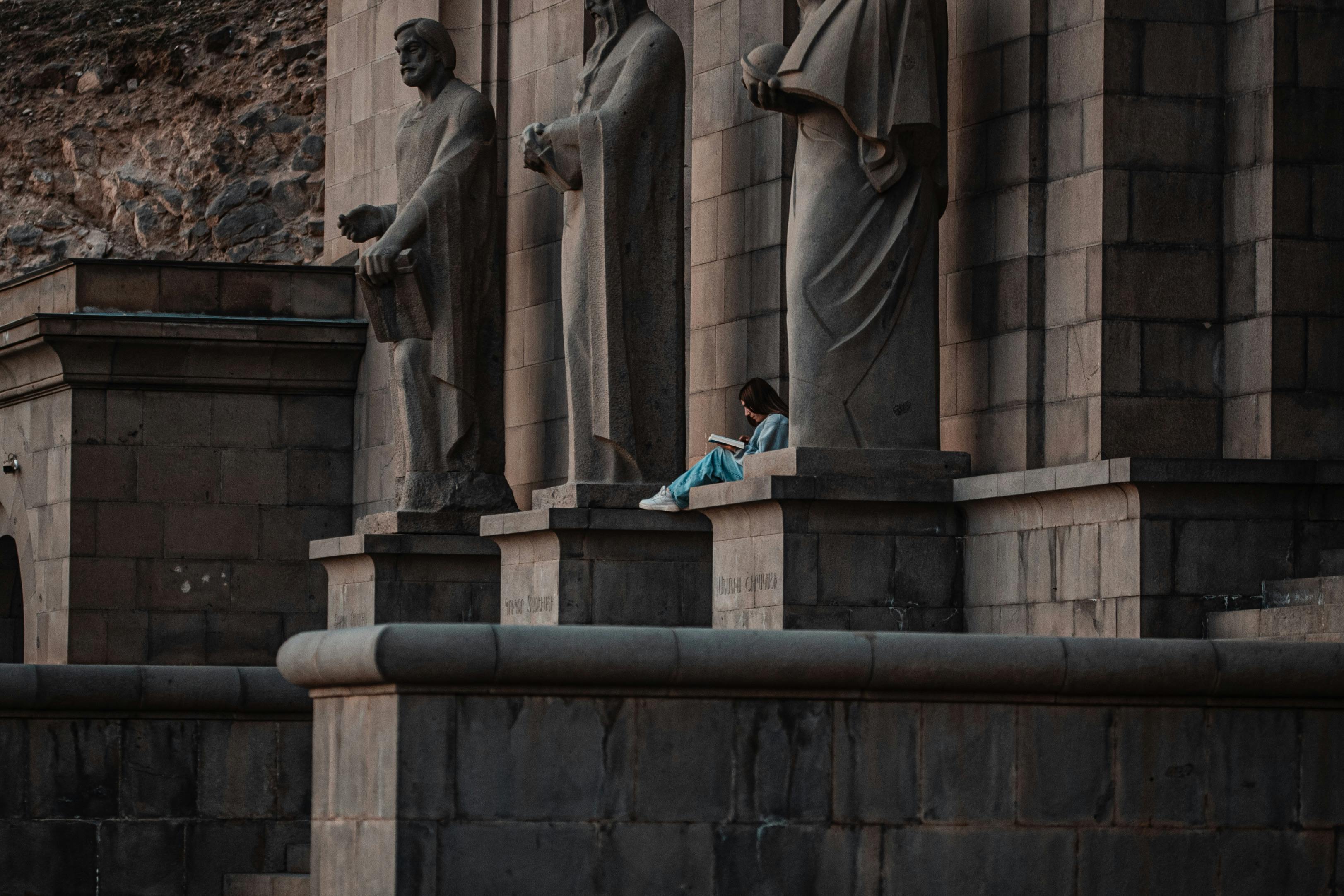 Solitary Reading Amidst Ancient Stone Statues · Free Stock Photo
