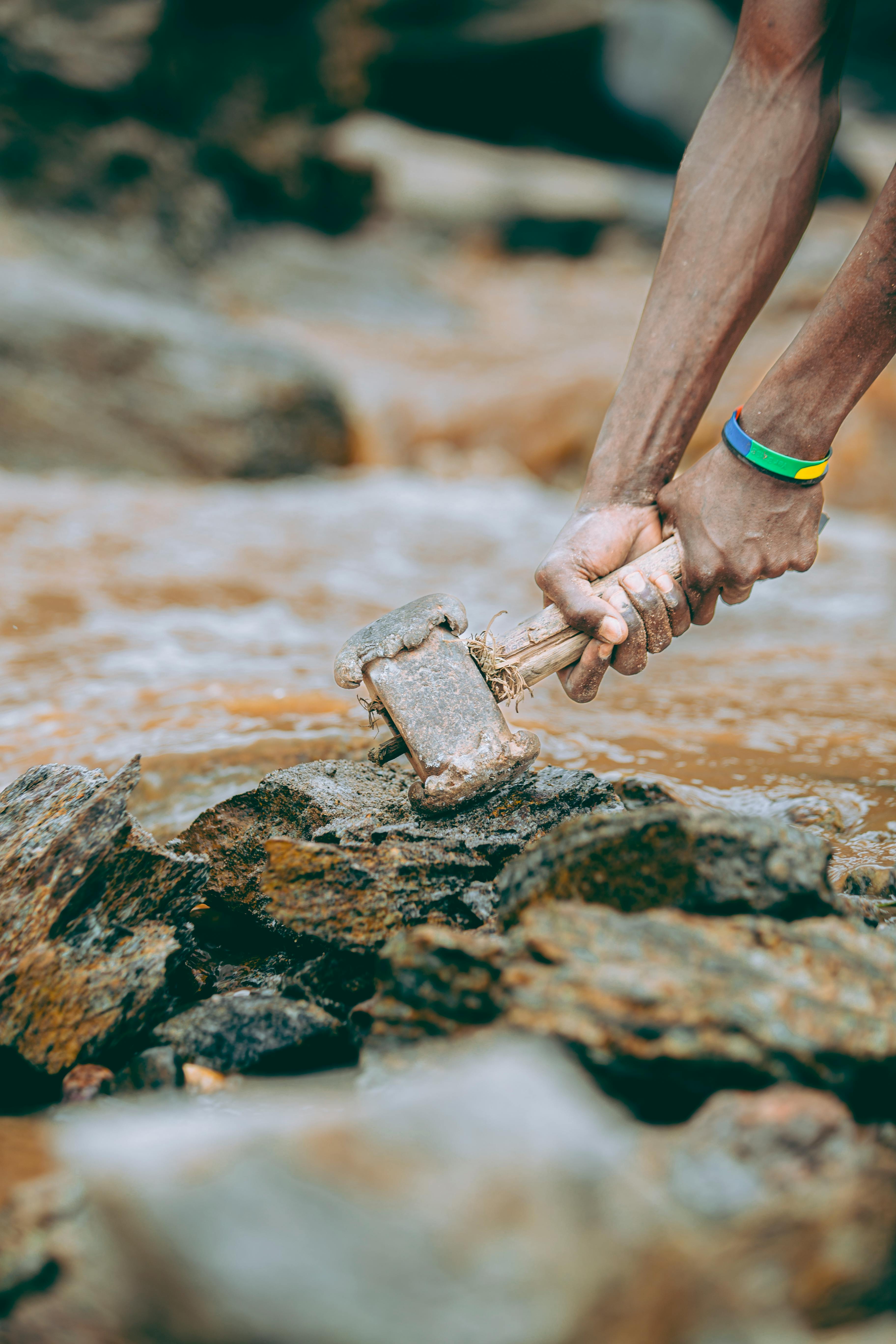 Worker Breaking Rock with Hammer Outdoors · Free Stock Photo