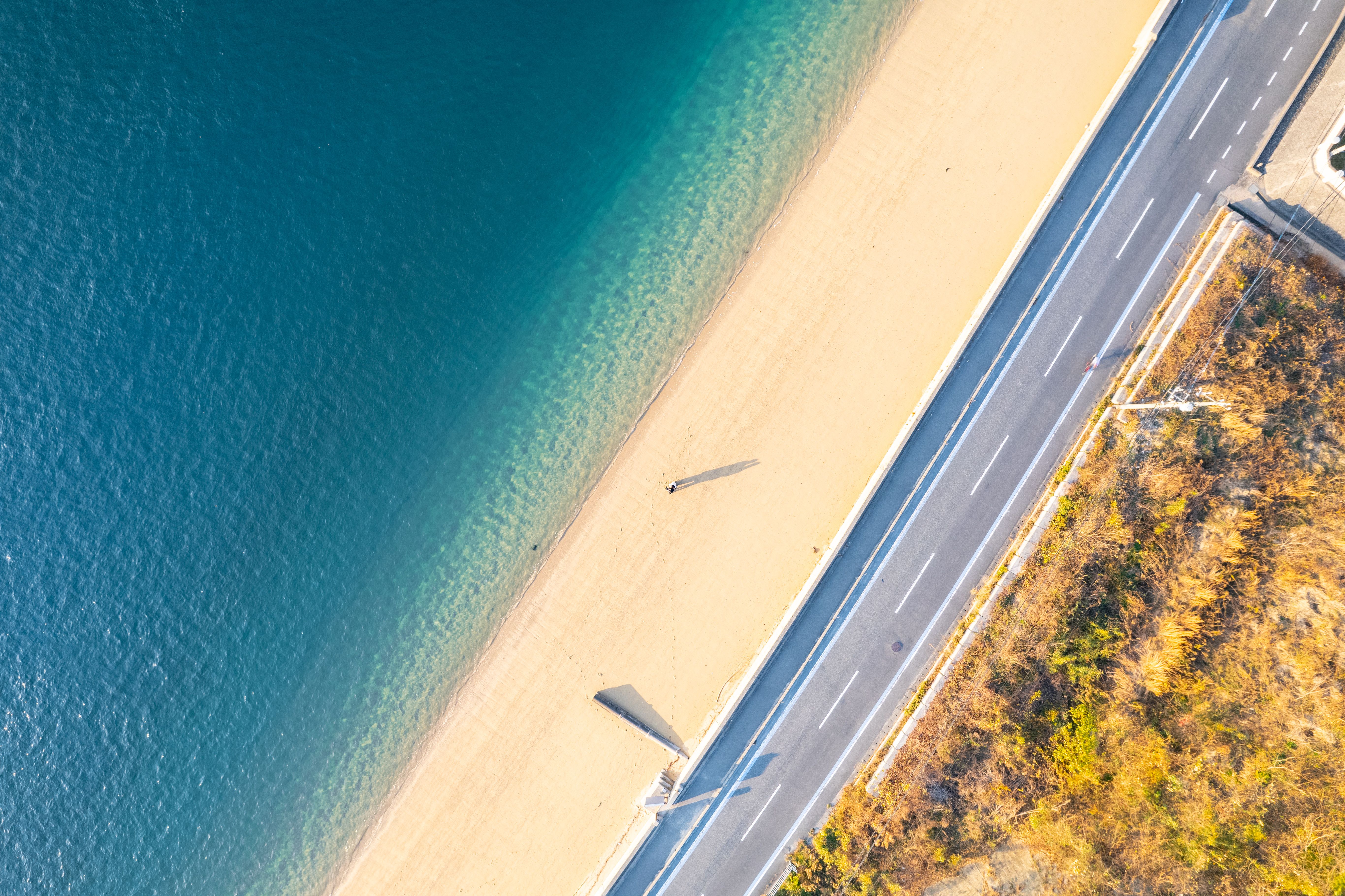 Aerial View of Coastal Road and Sandy Beach · Free Stock Photo
