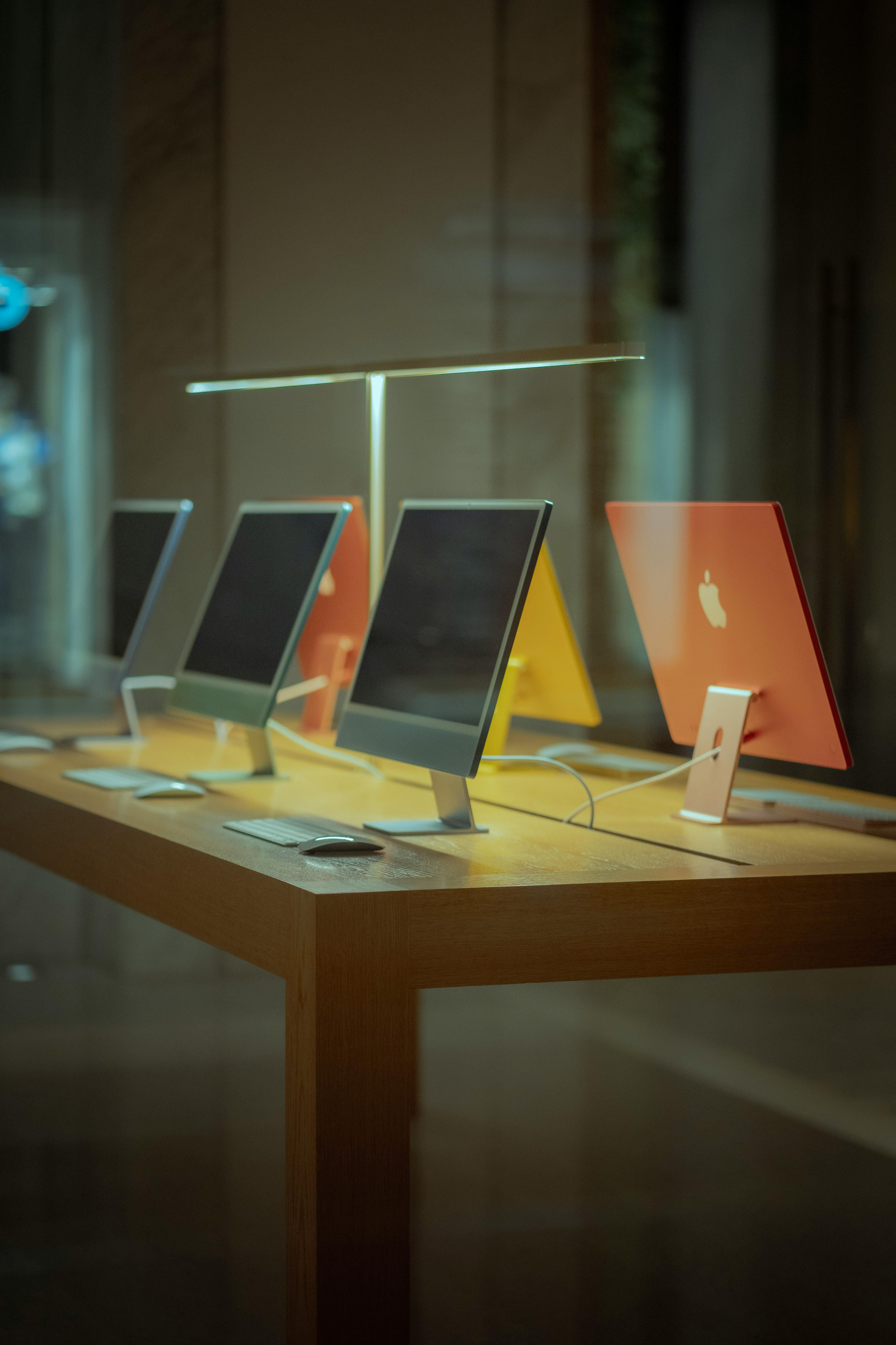 Row of Colorful Desktop Computers in Store Display · Free Stock Photo