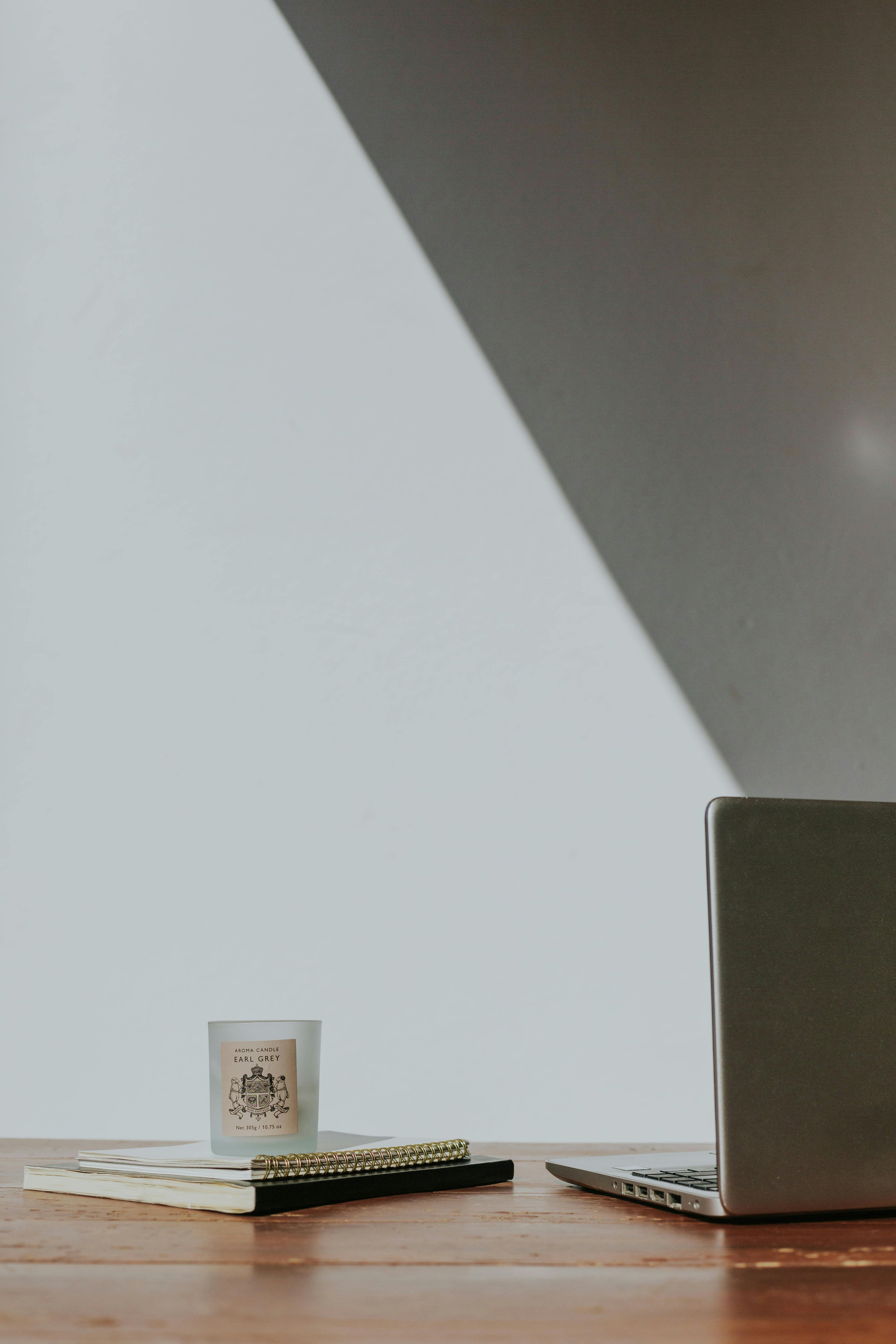 Minimalist Home Office Desk Setup with Laptop and Candle · Free Stock Photo