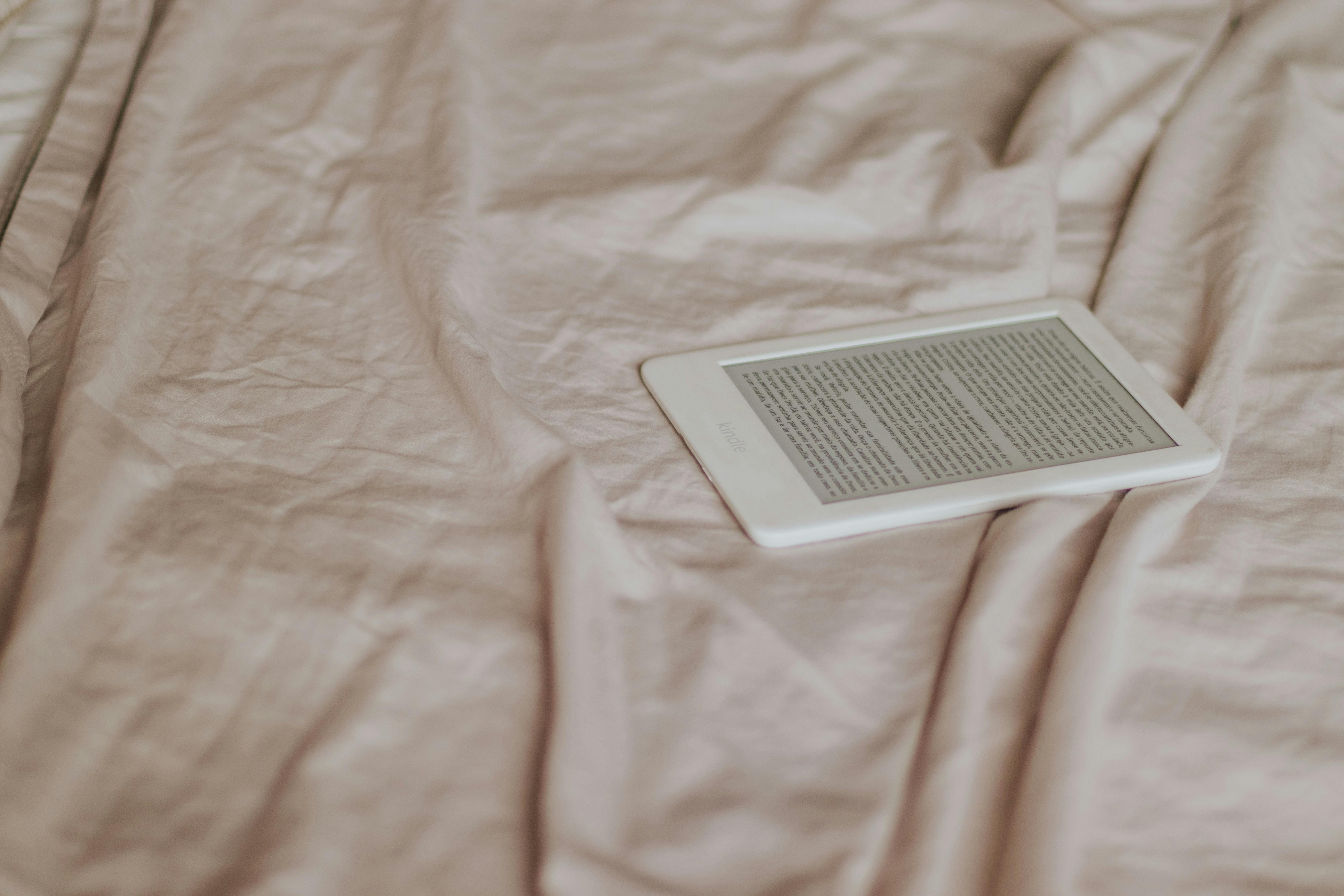 E-Reader on Beige Bedspread for Relaxed Reading · Free Stock Photo
