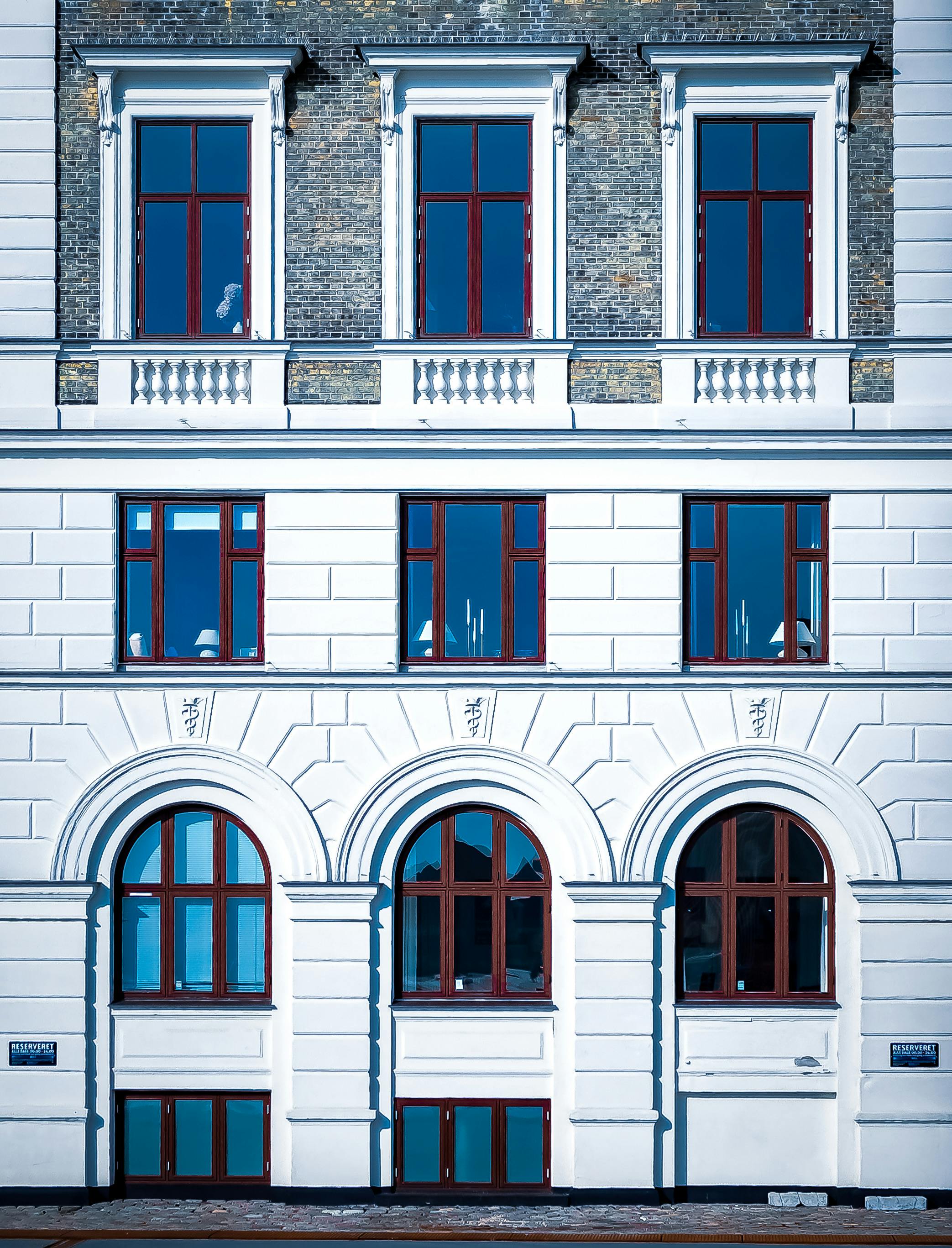 Elegant Neoclassical Building Facade with Arched Windows · Free Stock Photo