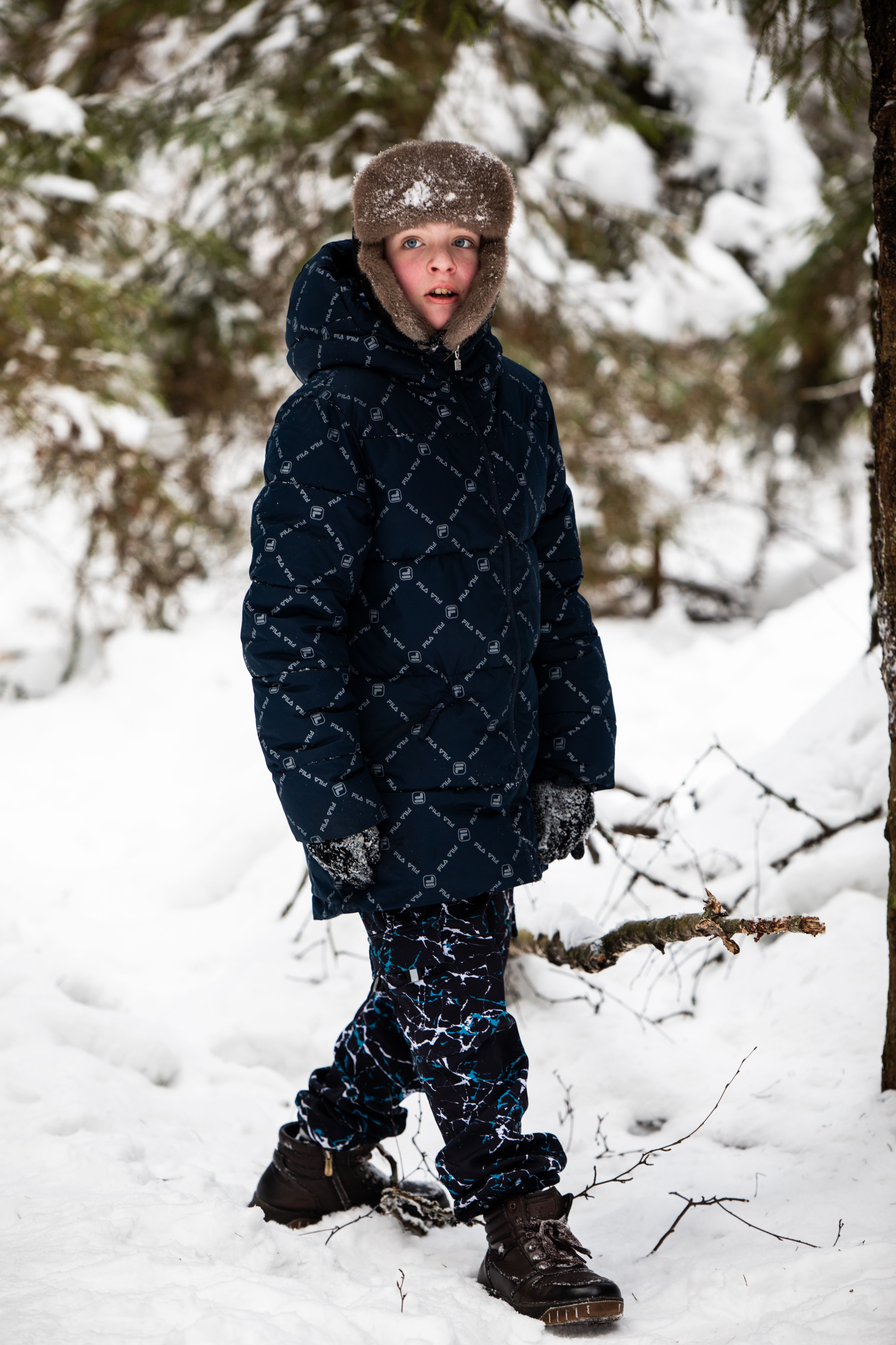 Child in Winter Clothing Exploring Snowy Forest · Free Stock Photo
