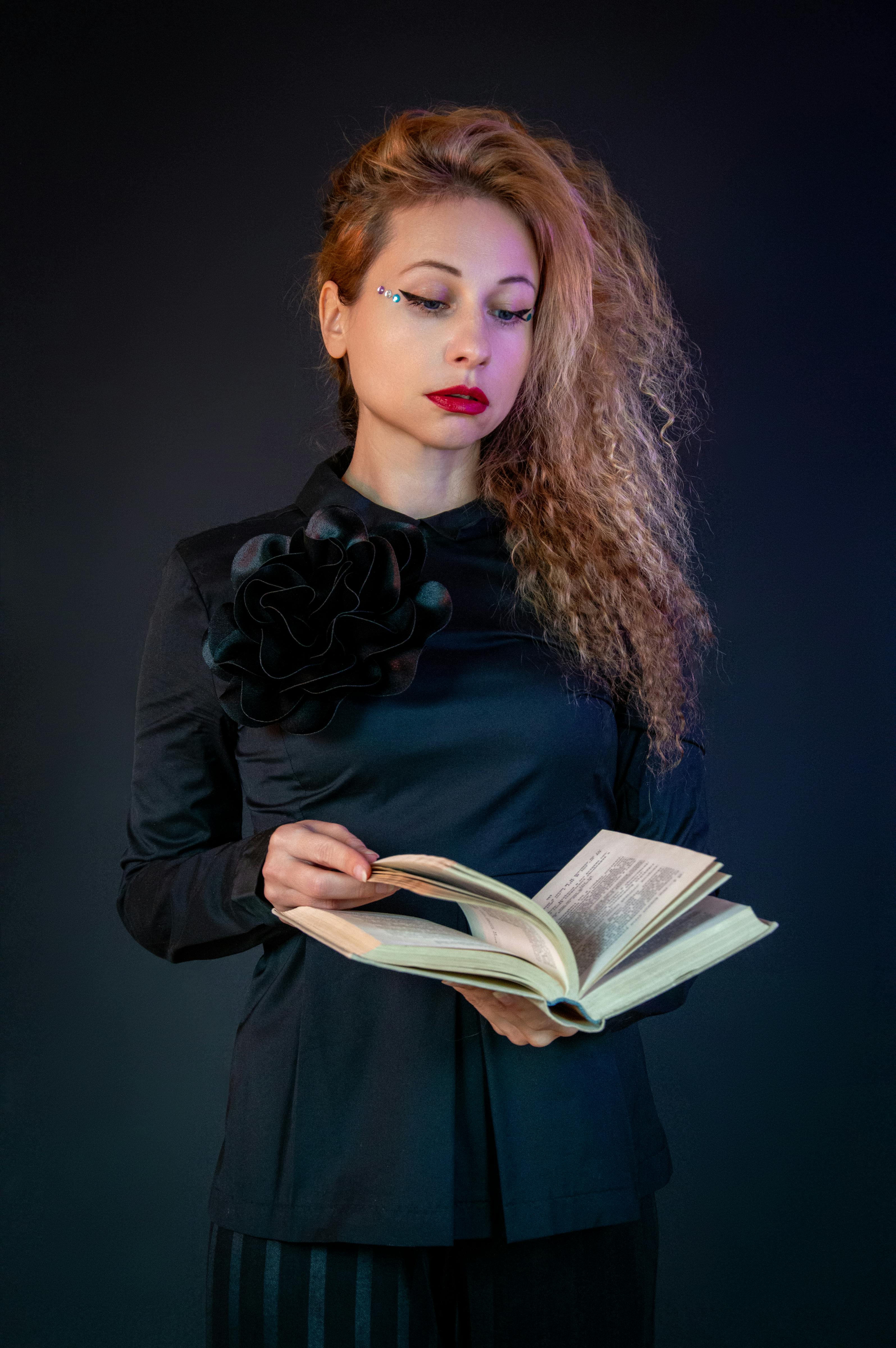 Elegant Woman Reading a Book in Dim Light · Free Stock Photo