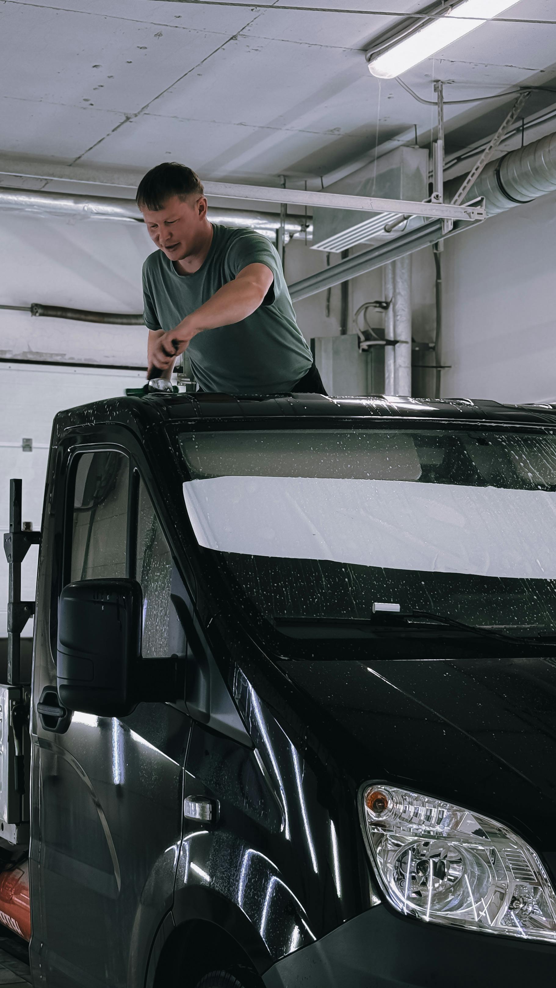 Hombre Limpiando El Techo De Una Furgoneta En Un Garaje Industrial ...