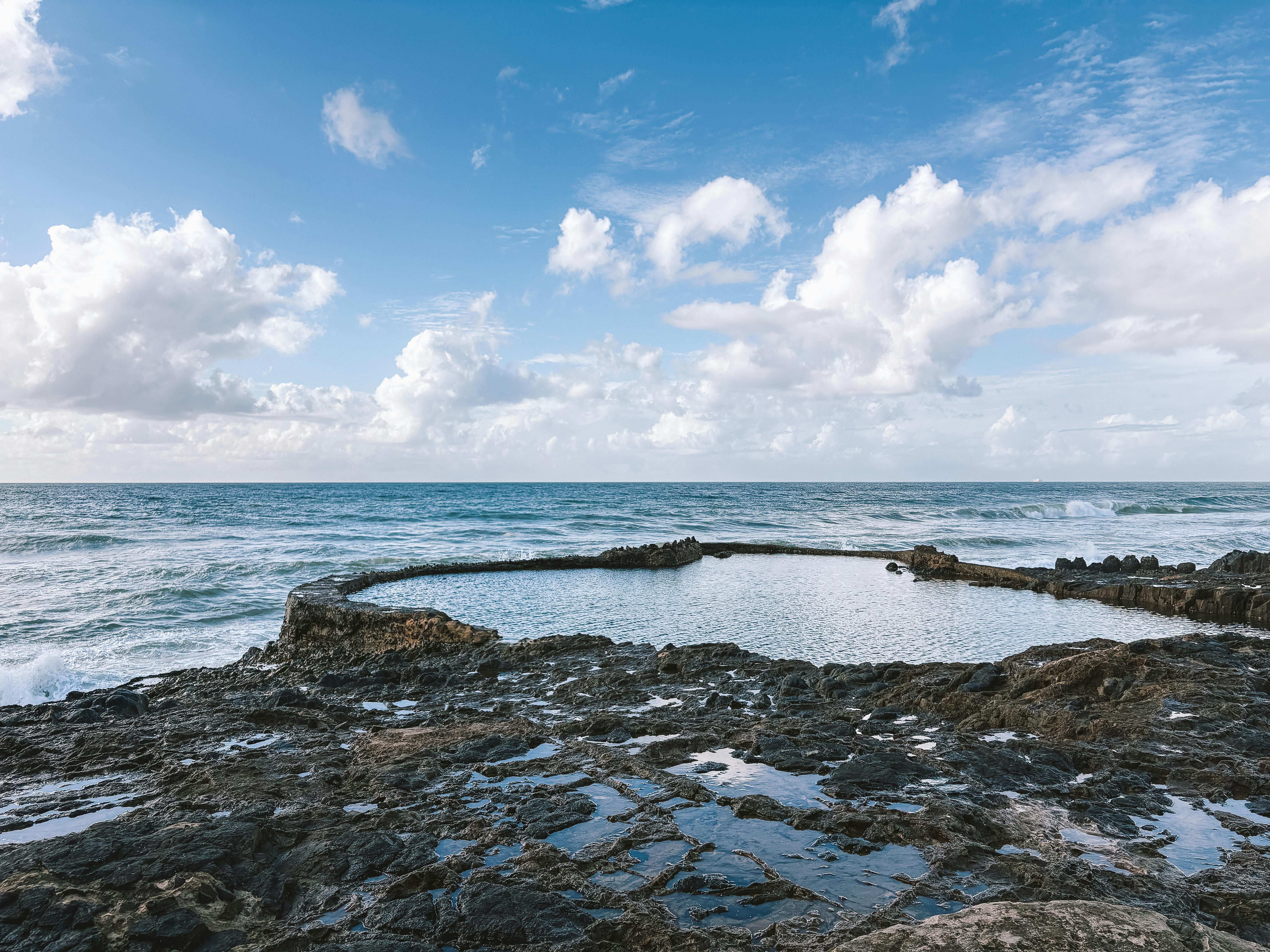 Serene Coastal Rock Pool Overlooking Ocean · Free Stock Photo