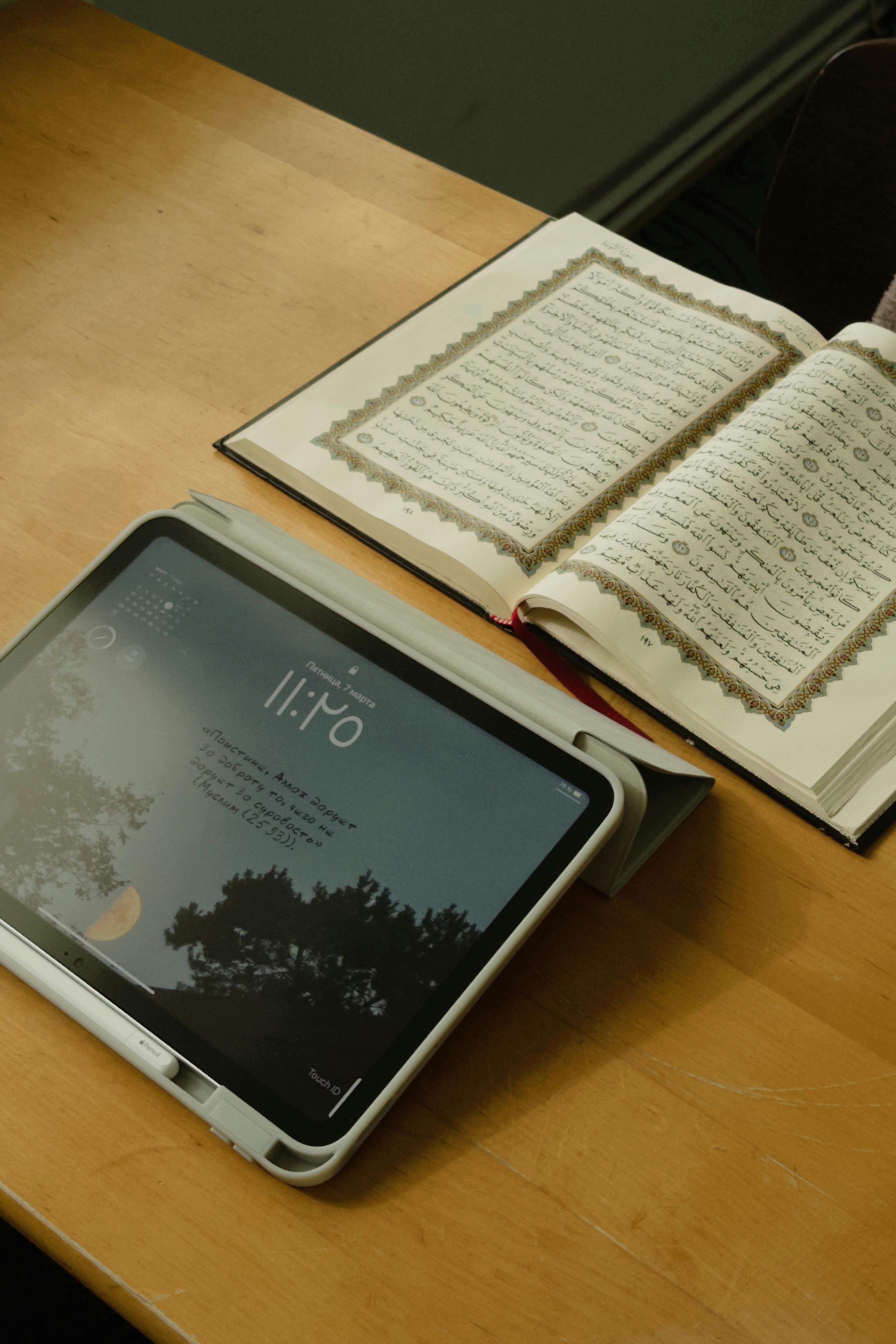 Holy Quran and Tablet on Wooden Table with Reflection · Free Stock Photo