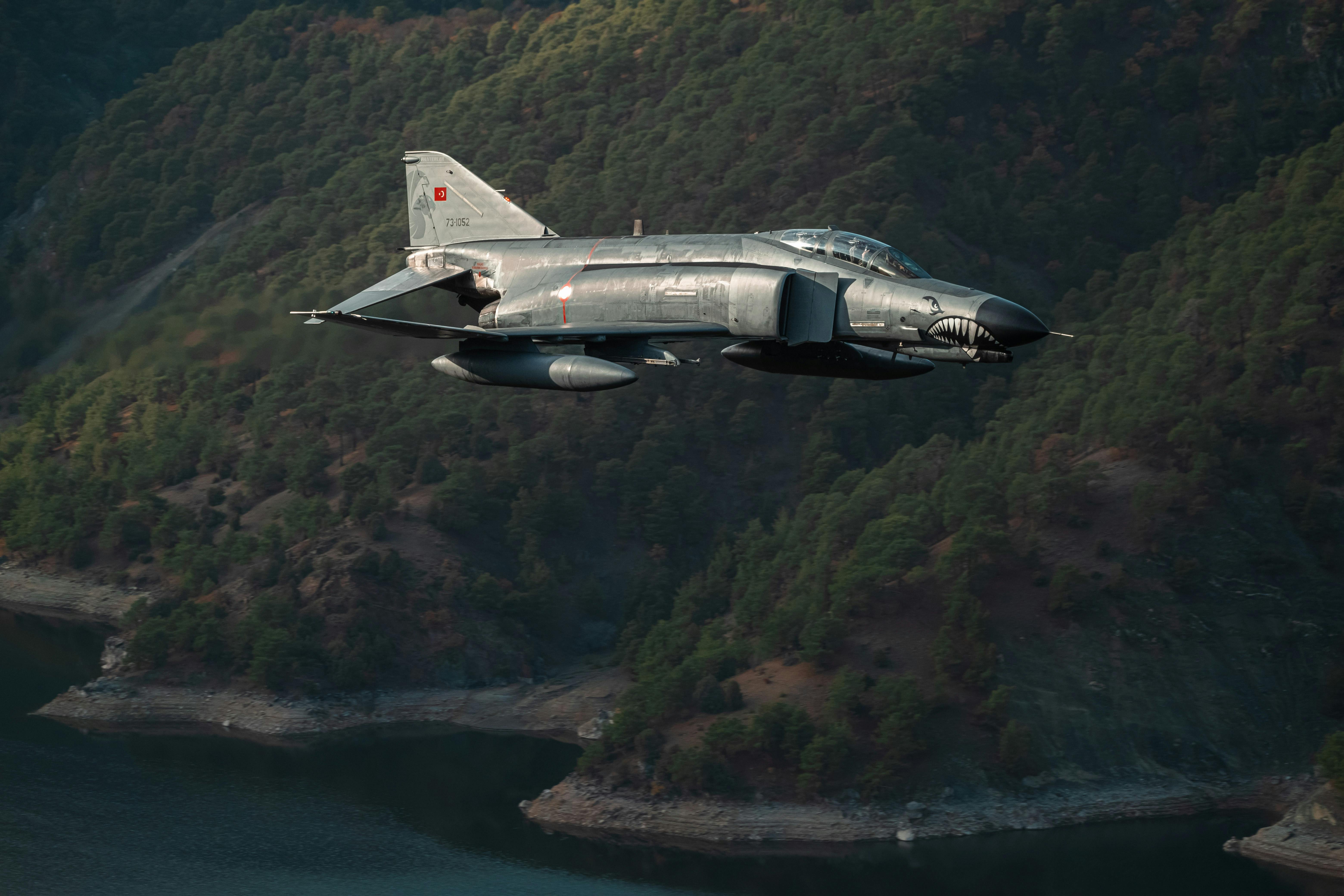 Turkish Fighter Jet Flying Over Forested Landscape · Free Stock Photo