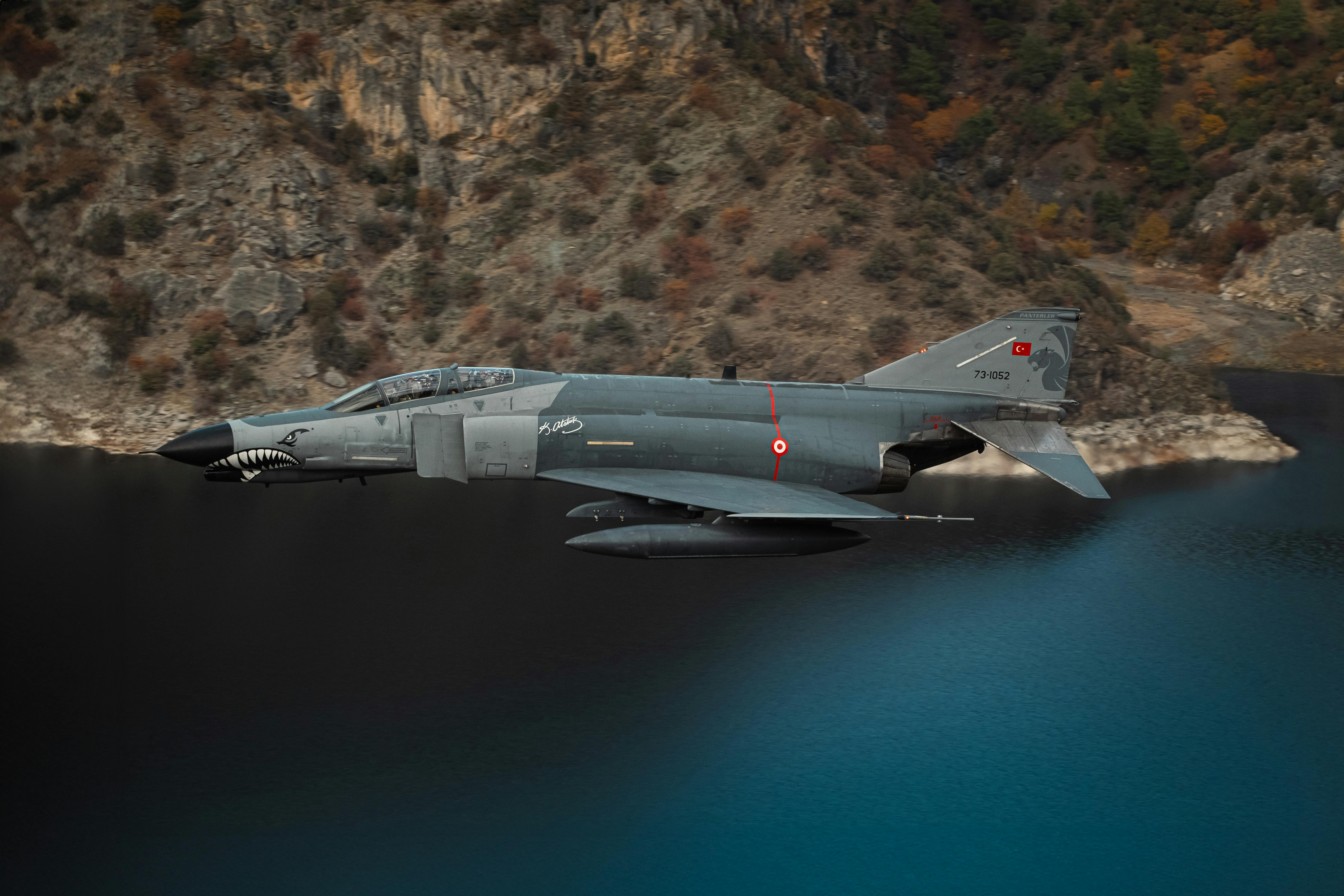 Turkish F-4 Jet Fighter Over Water and Cliffs · Free Stock Photo