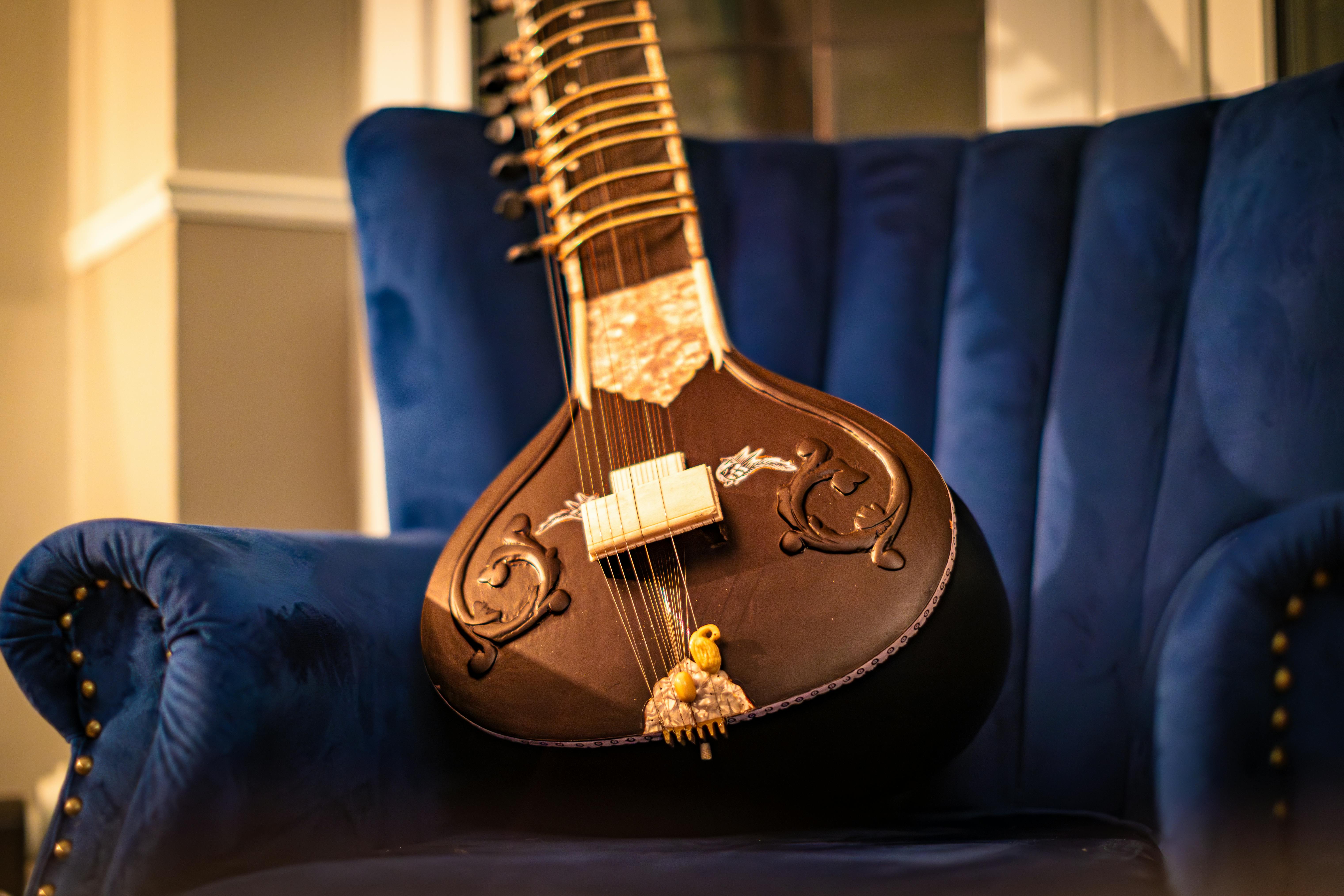 Exquisite Sitar on Blue Velvet Chair Indoors · Free Stock Photo