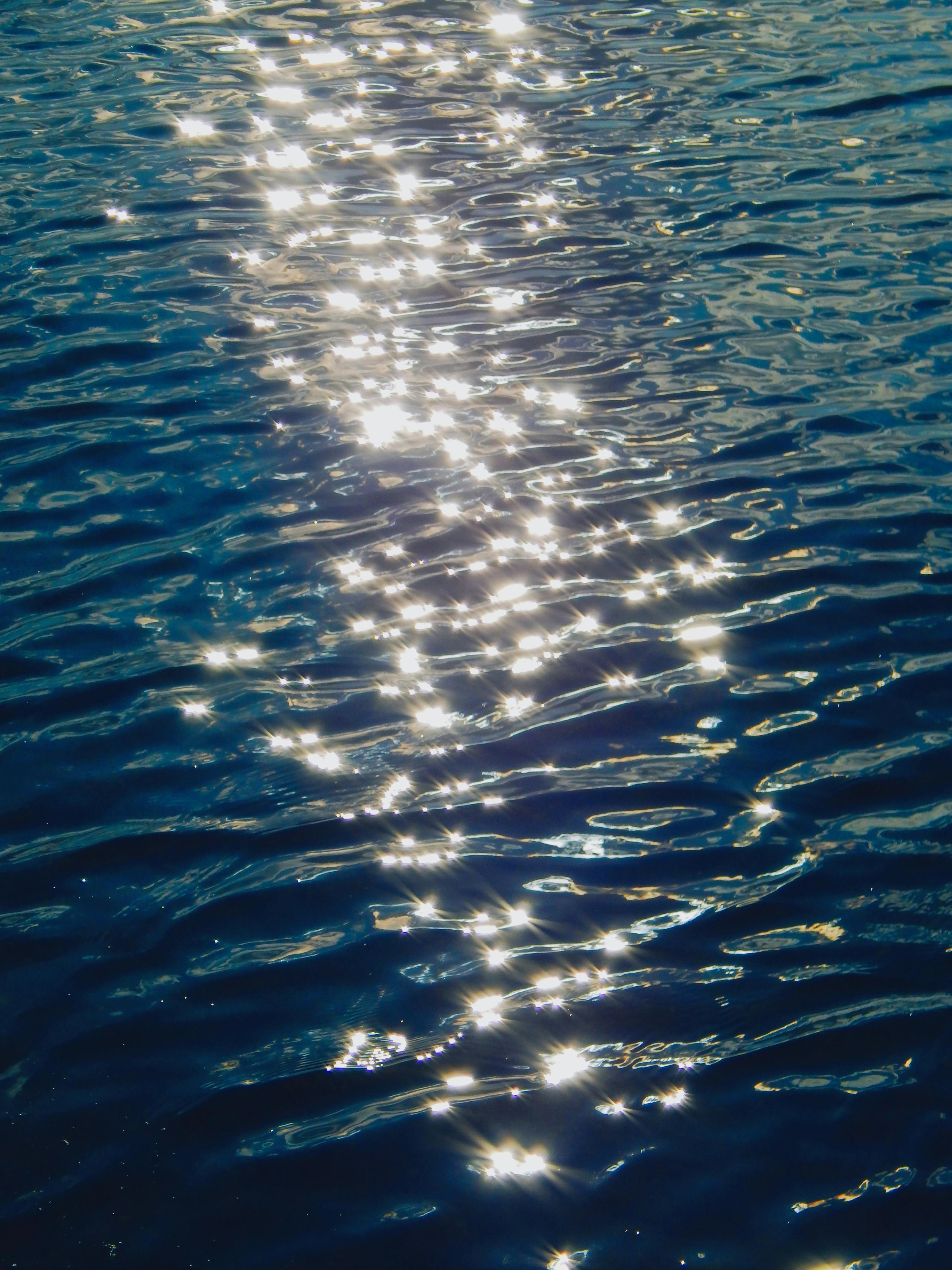 Shimmering Sunlight on Rippling Water Surface · Free Stock Photo