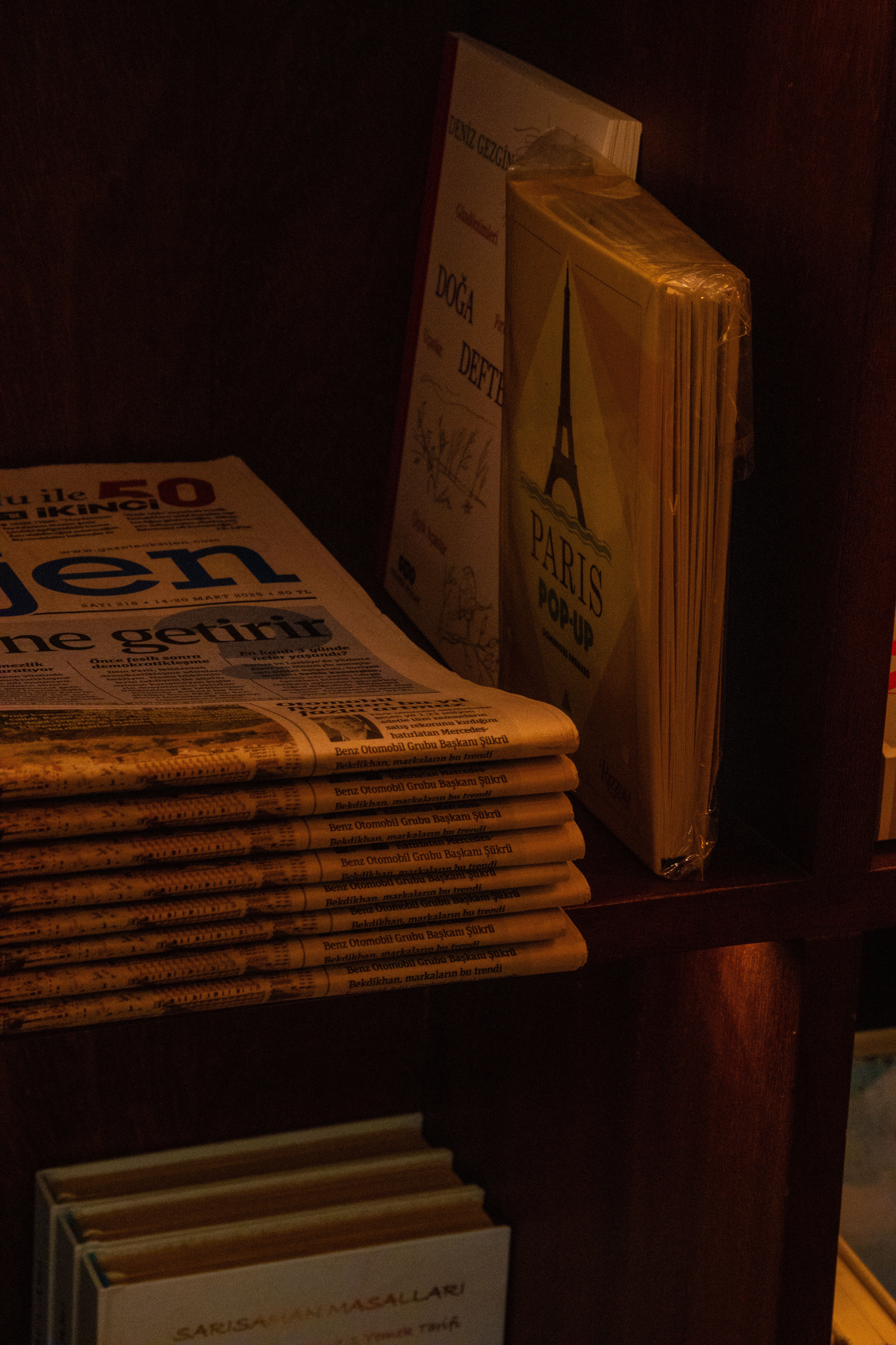Cozy Bookshelf with Newspapers and Paris Pop-Up Book · Free Stock Photo