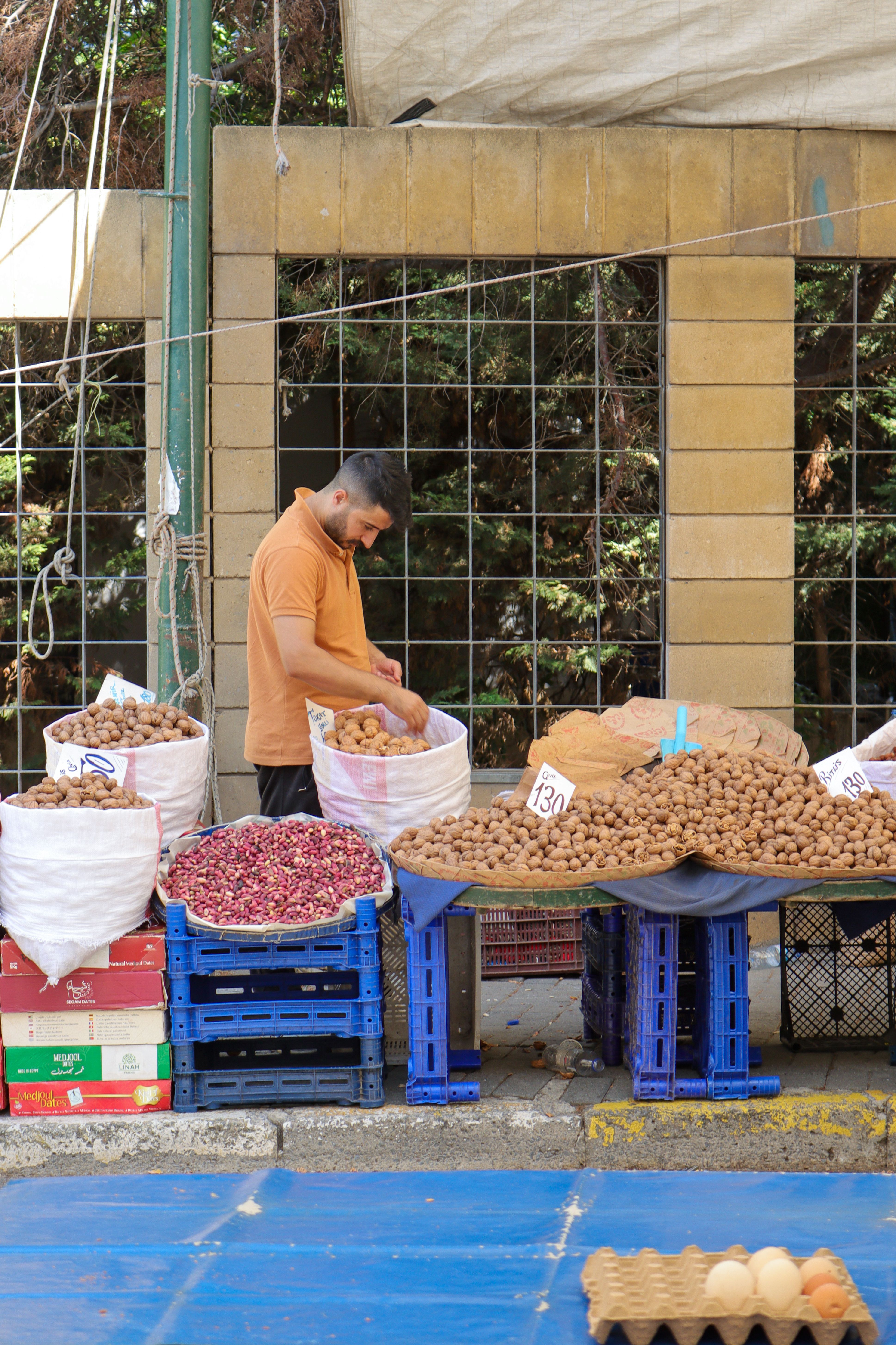 Man Arranging Produce at Outdoor Market · Free Stock Photo