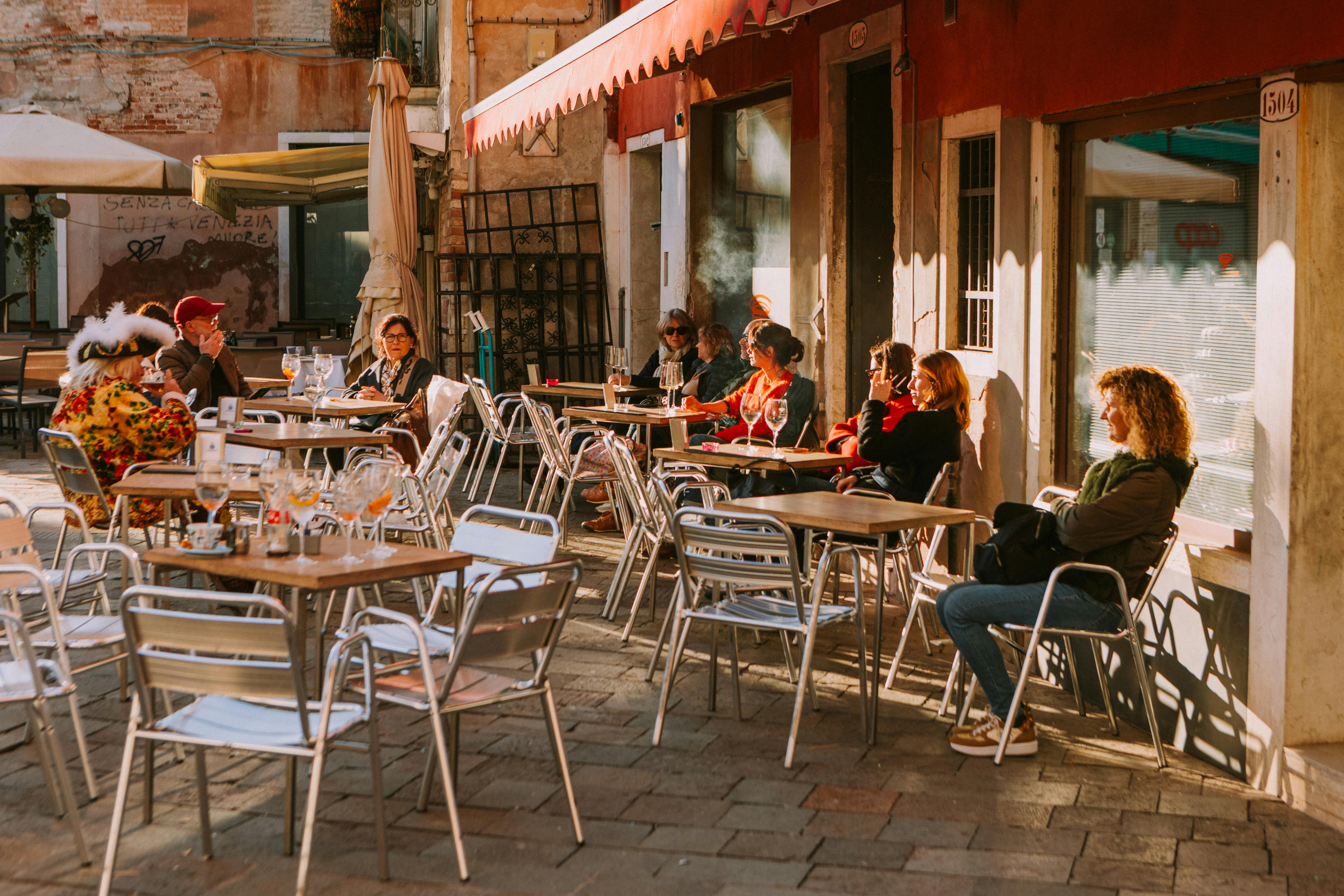 Charming Outdoor Cafe Seating in Sunlit Alley · Free Stock Photo