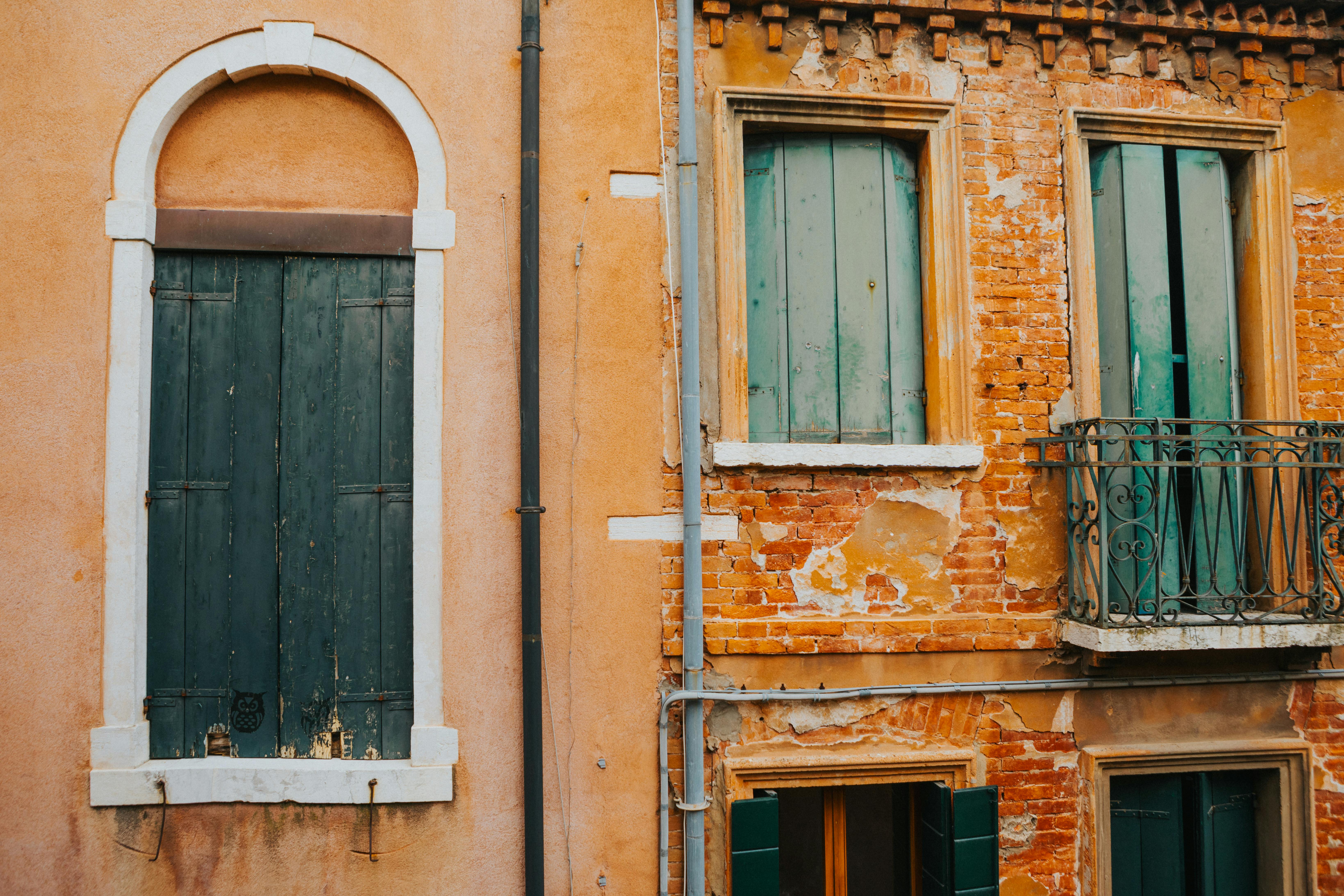 Rustic Facade in Warm Tones with Shuttered Windows · Free Stock Photo
