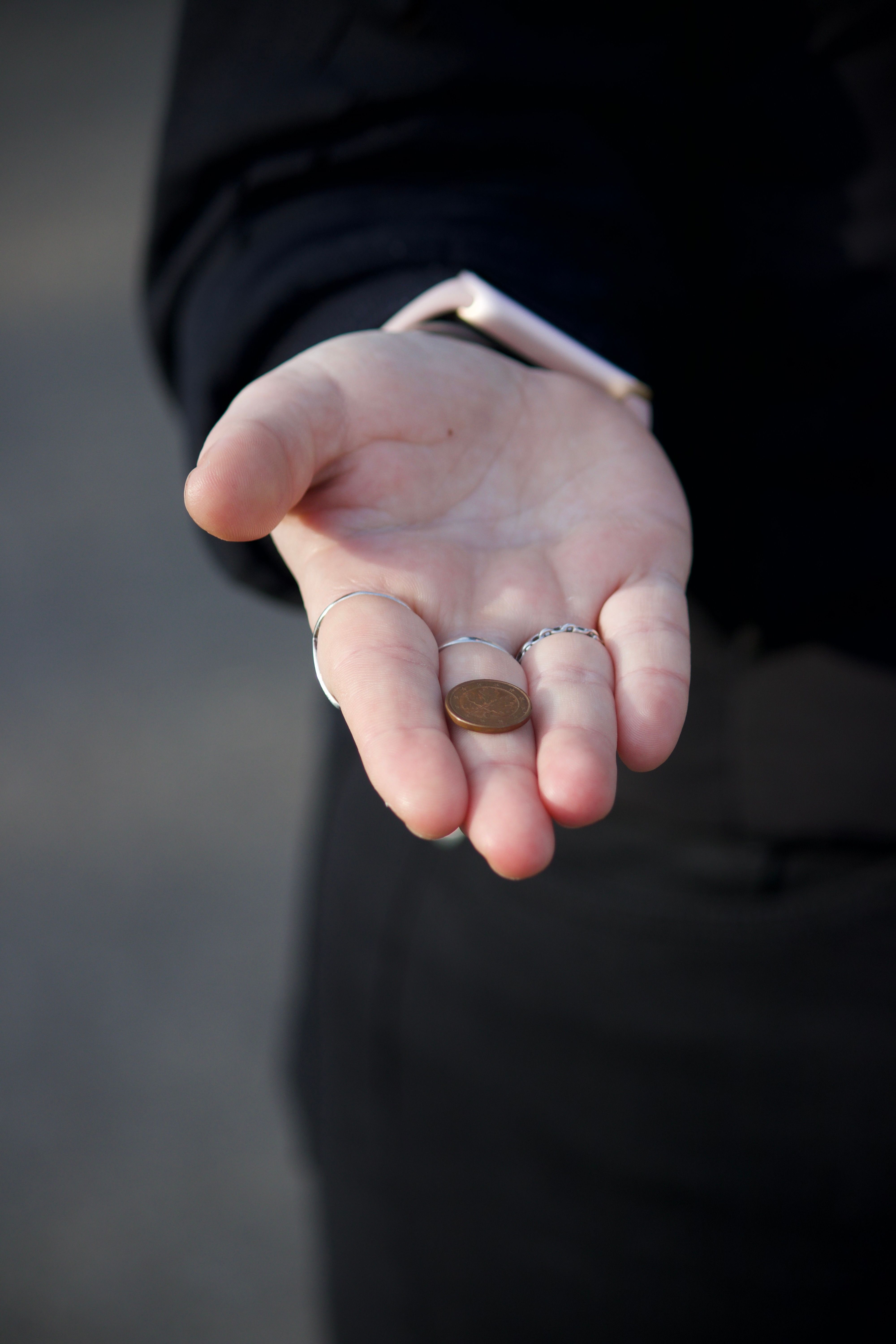 Closeup of Hand Holding a Coin Outdoors · Free Stock Photo