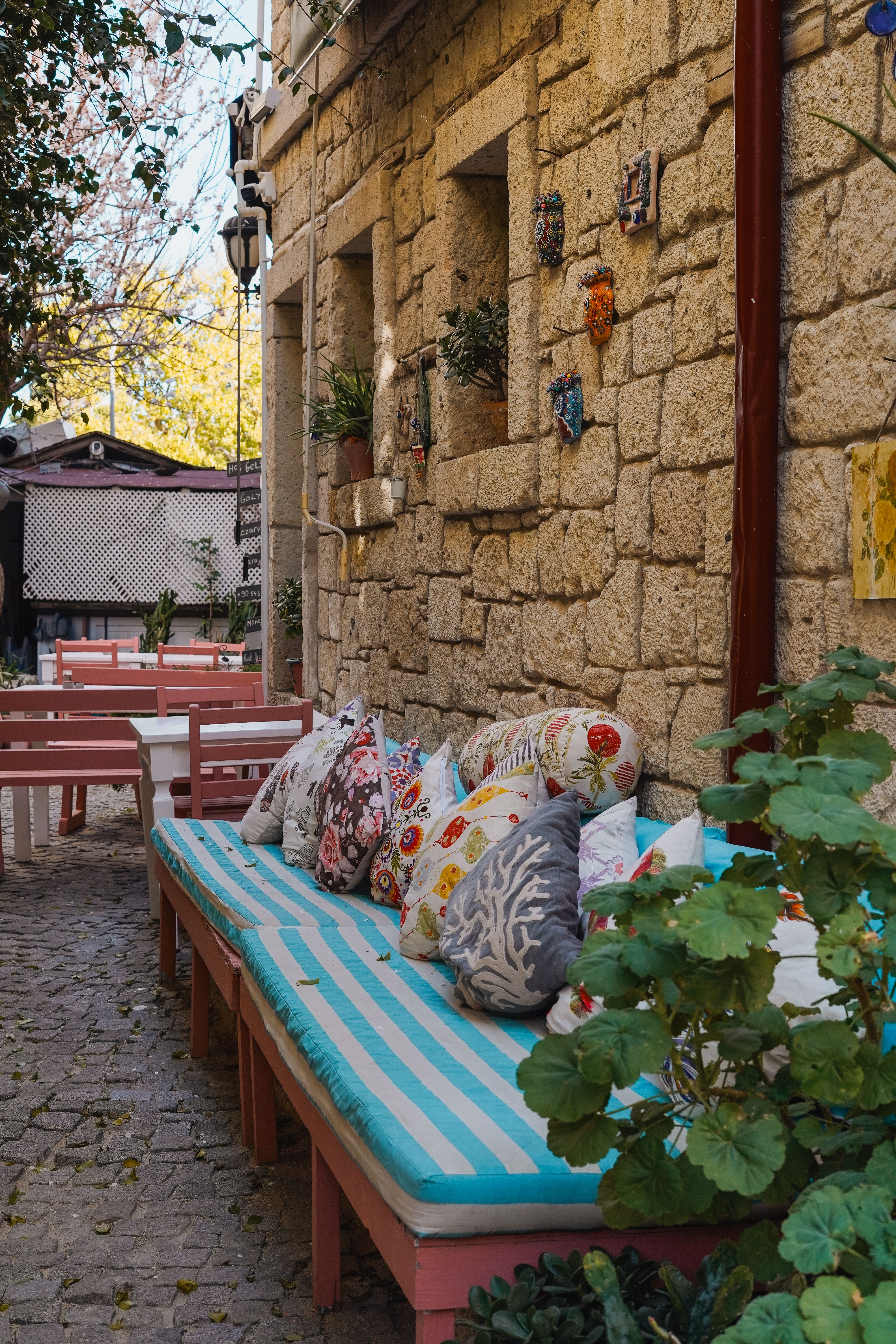 Charming Outdoor Cafe with Colorful Cushions · Free Stock Photo