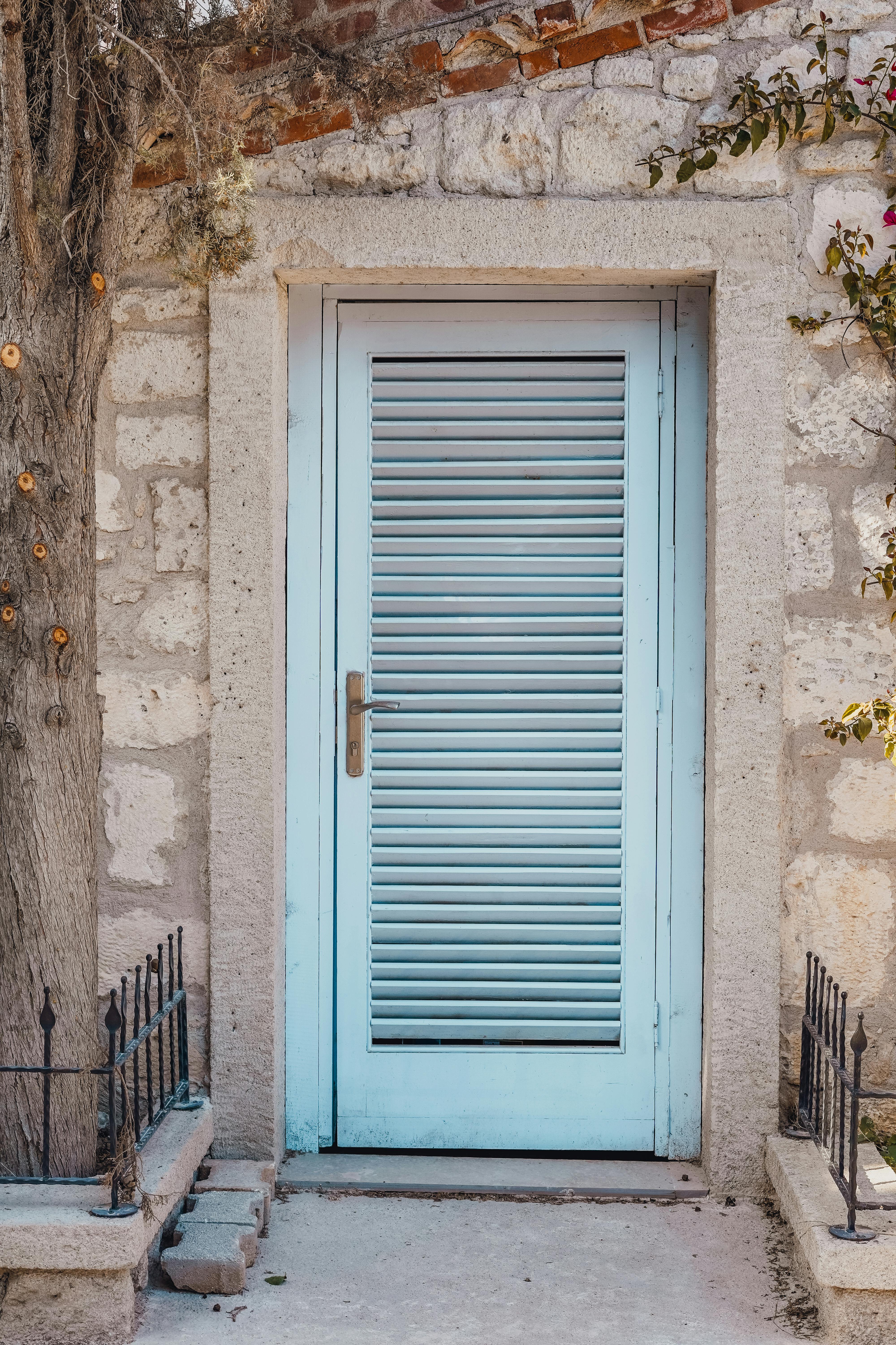 Charming Rustic Blue Door against Stone Wall · Free Stock Photo