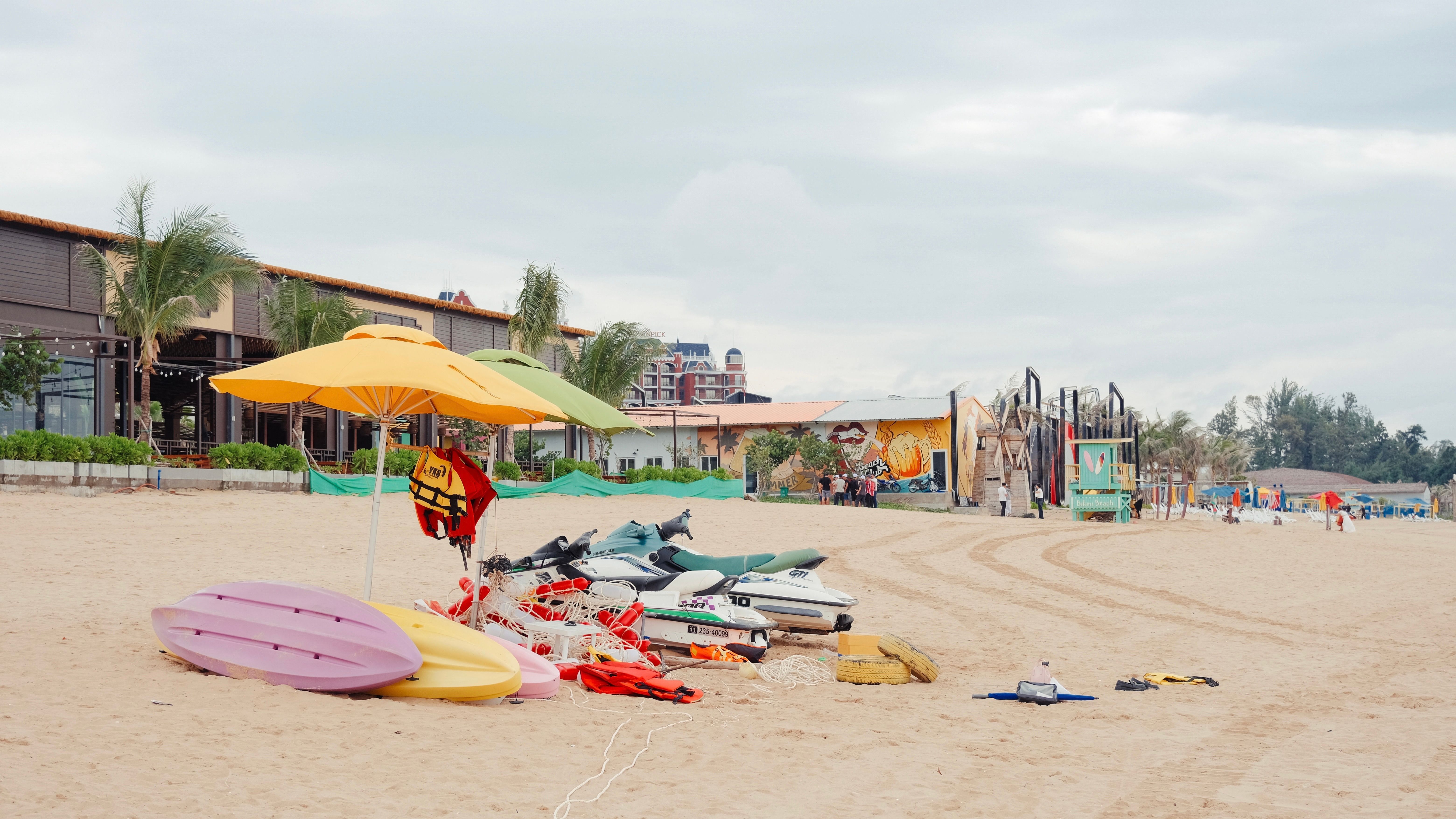Vibrant Beach Scene with Jet Skis and Umbrellas · Free Stock Photo