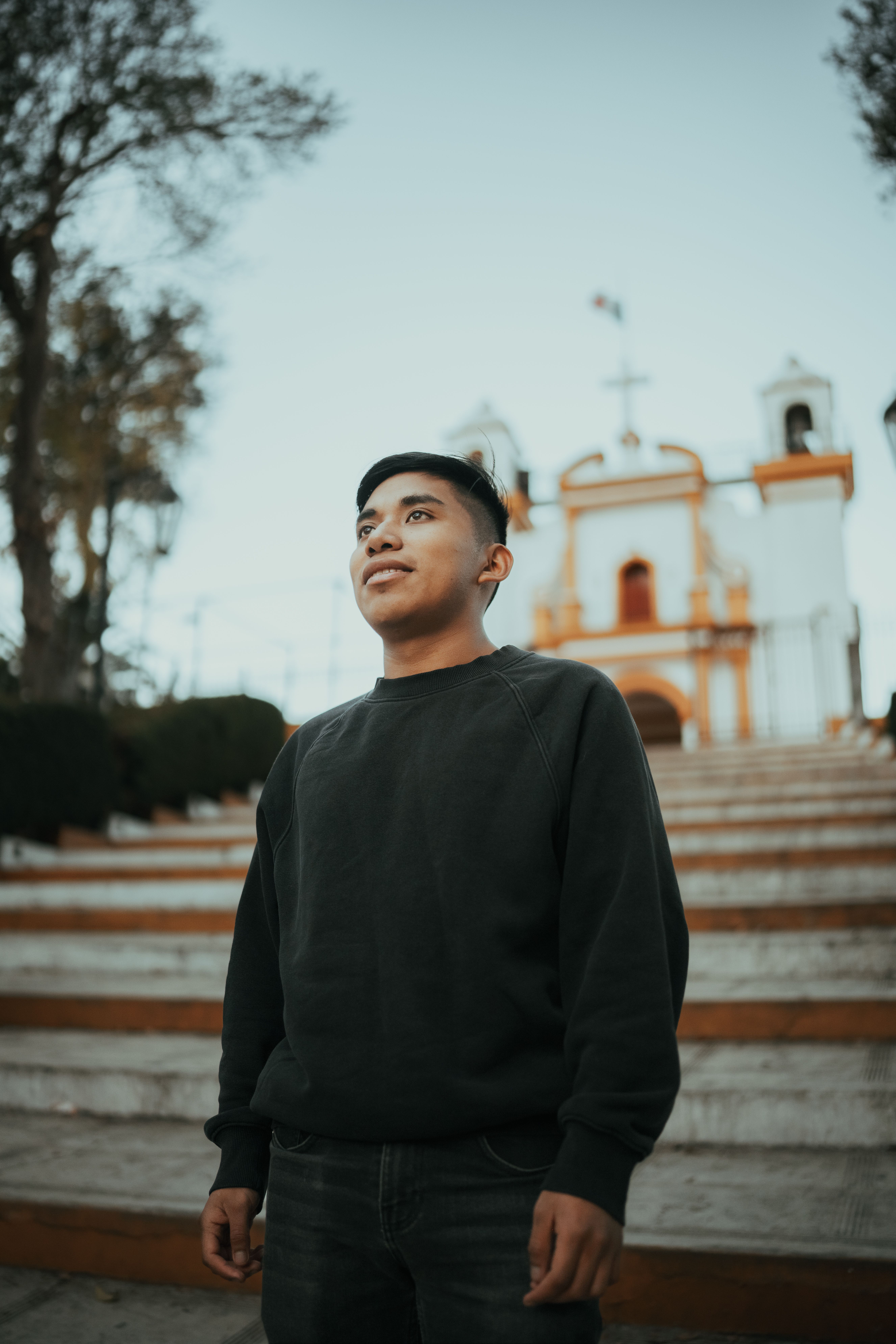 Young man standing in front of historical church · Free Stock Photo