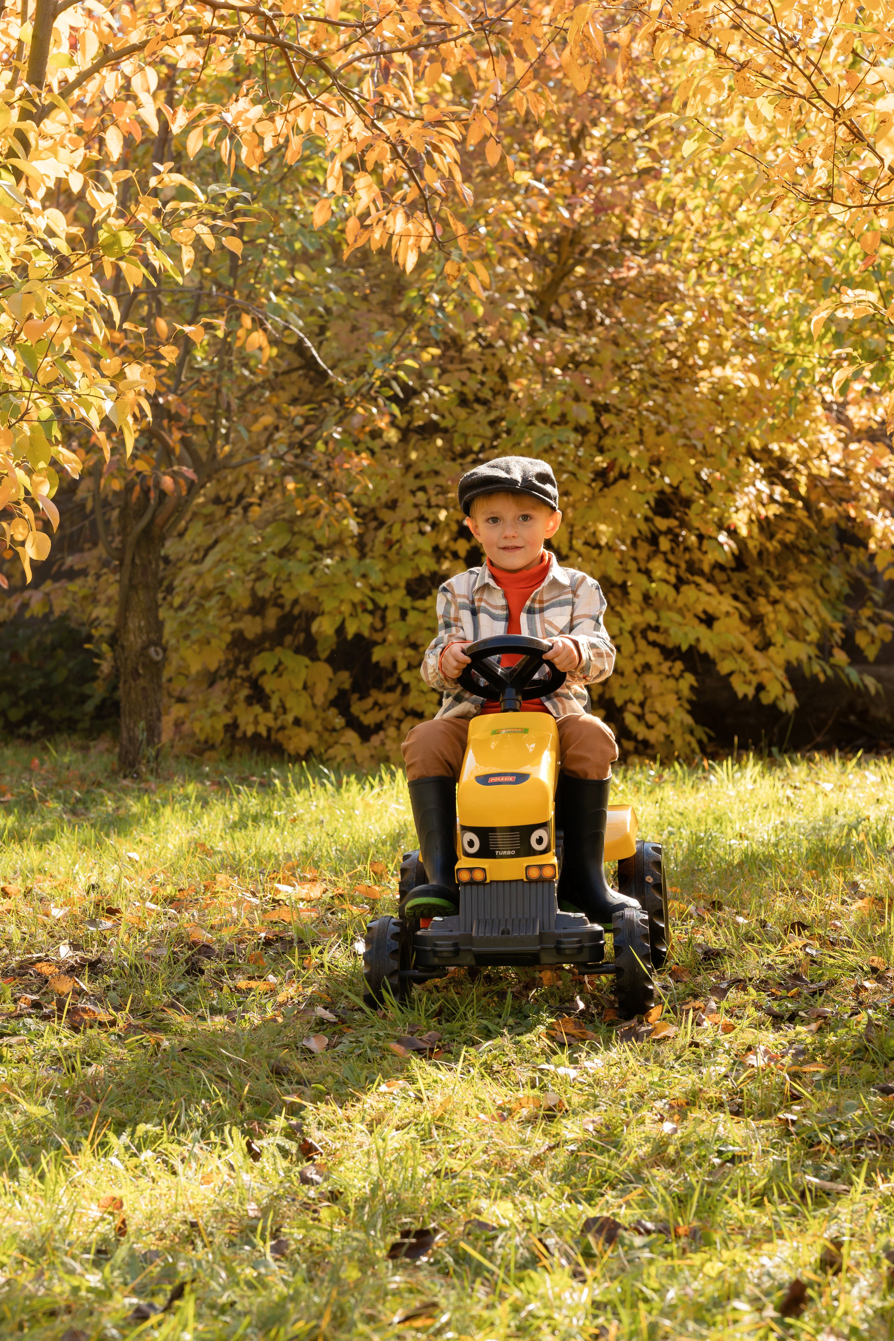 Child Riding Toy Tractor in Autumn Farm · Free Stock Photo