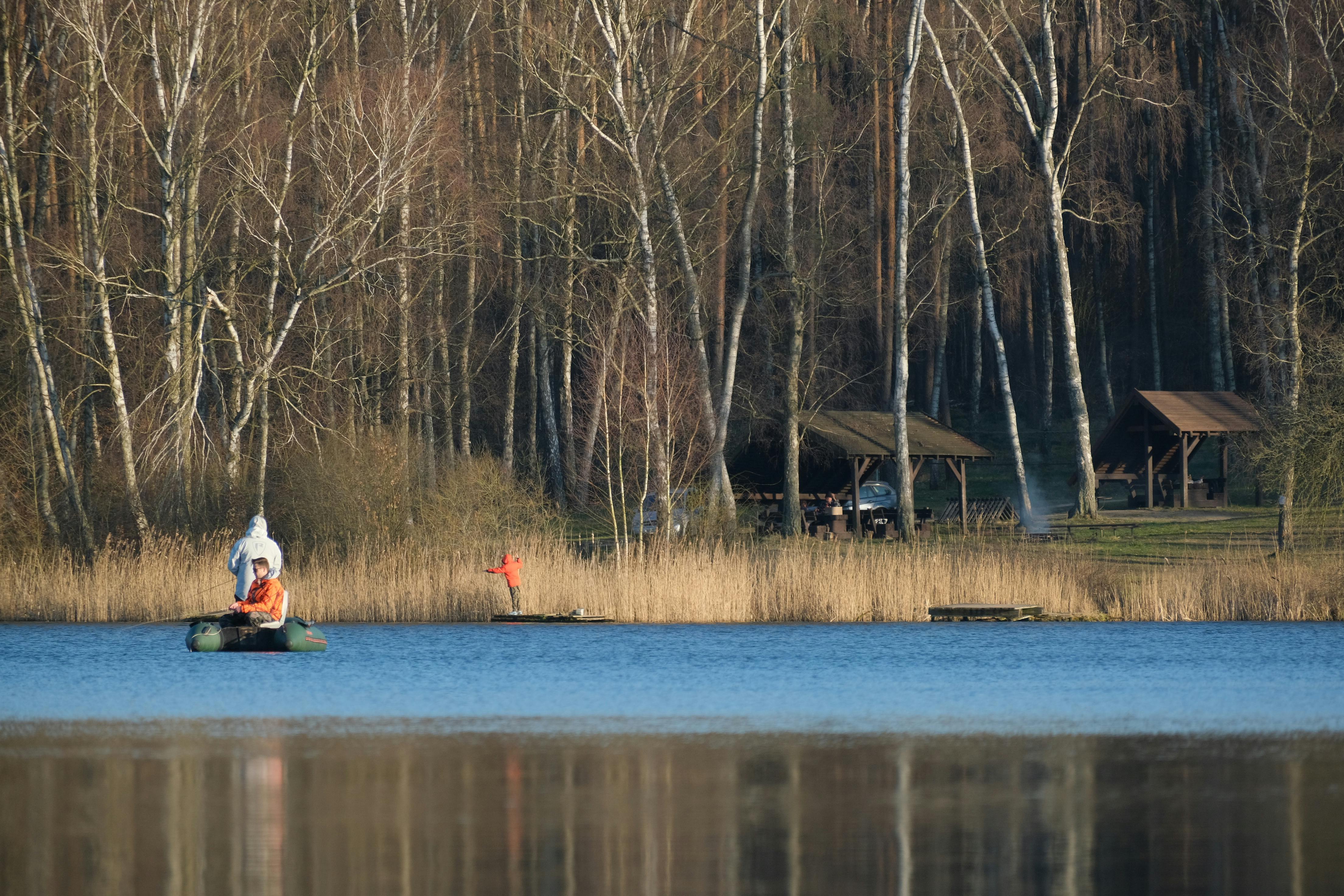 Peaceful Lake View with People Kayaking · Free Stock Photo