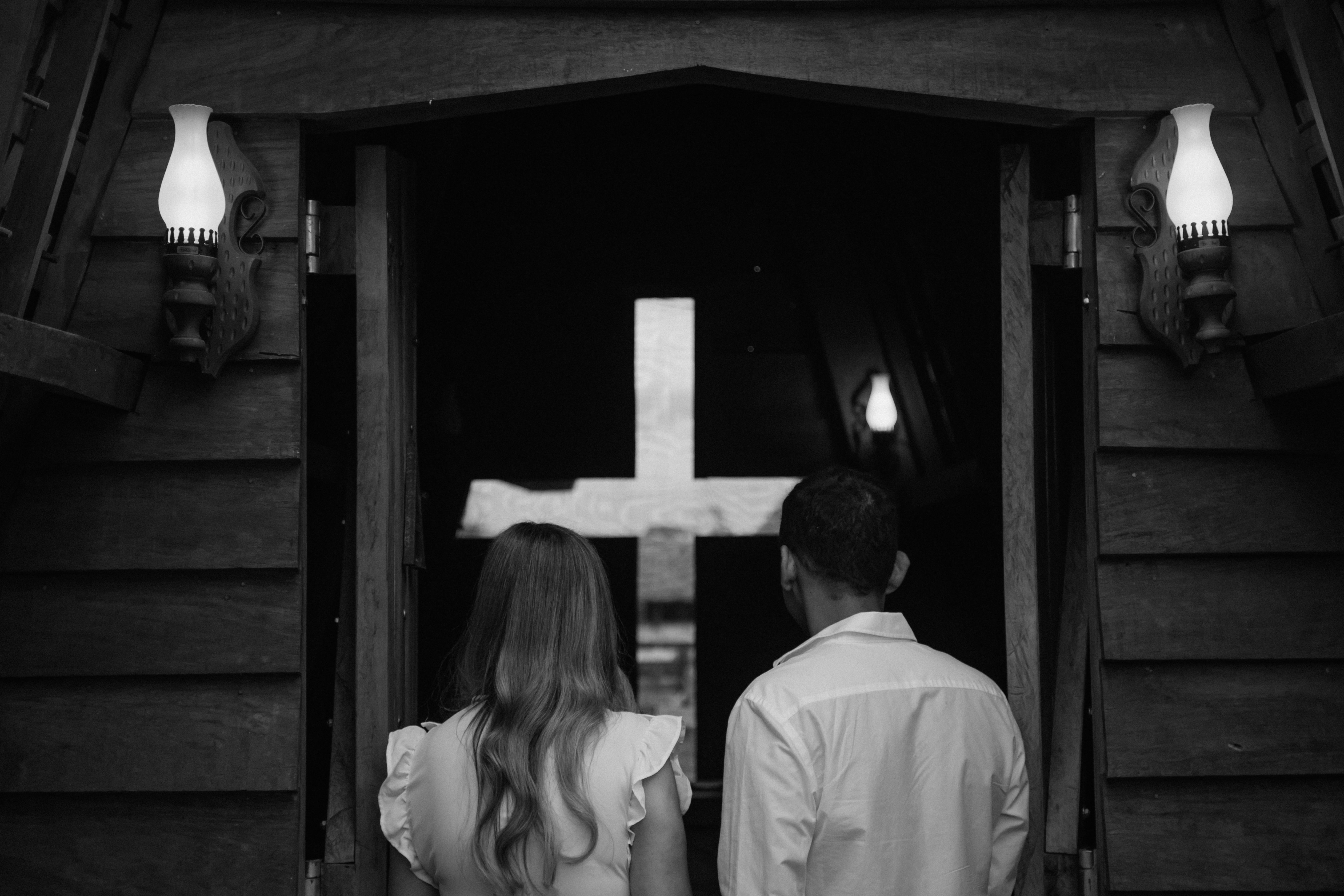 Couple Entering Church with Wooden Cross · Free Stock Photo