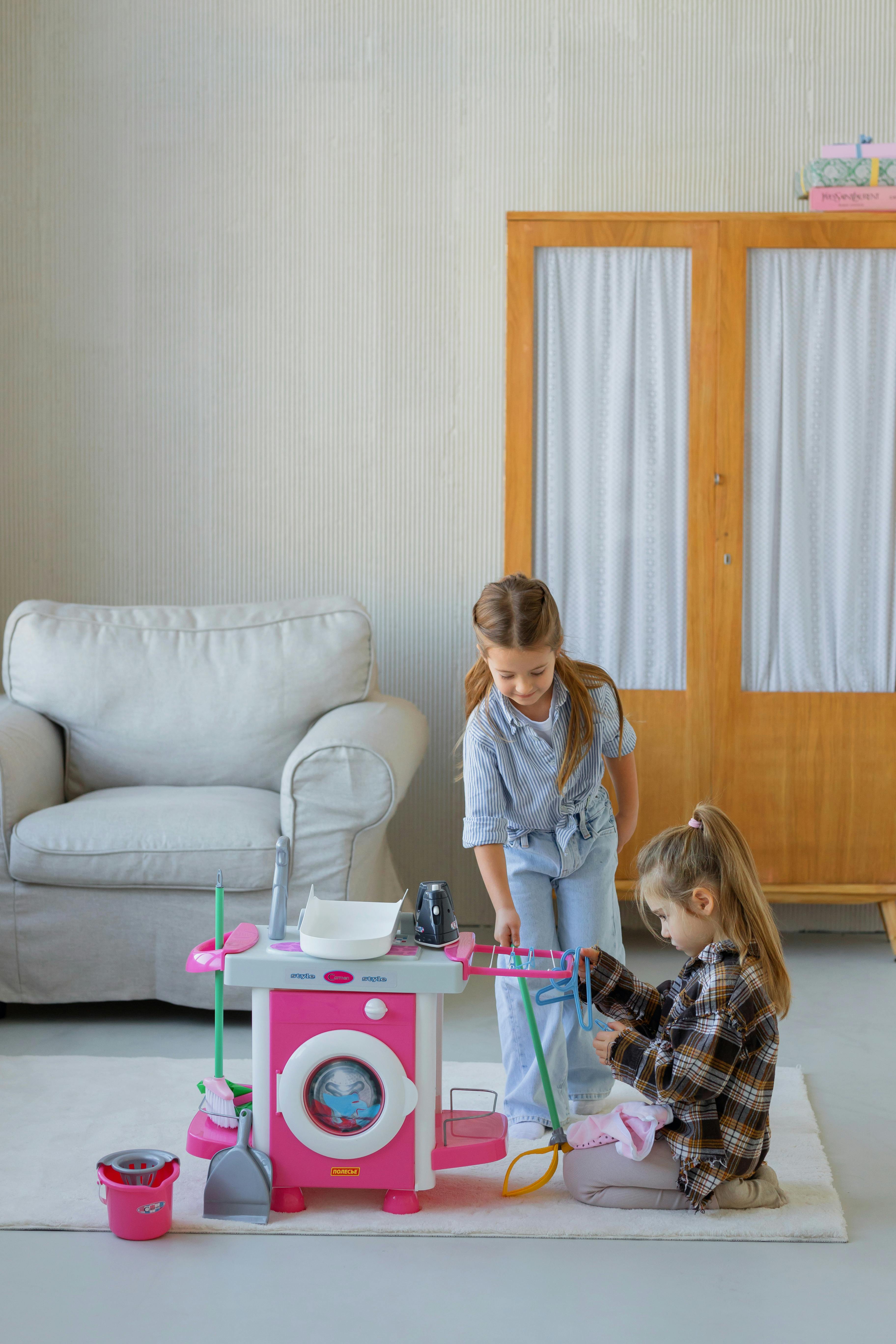 Two Kids Playing with Toy Laundry Set in Living Room · Free Stock Photo