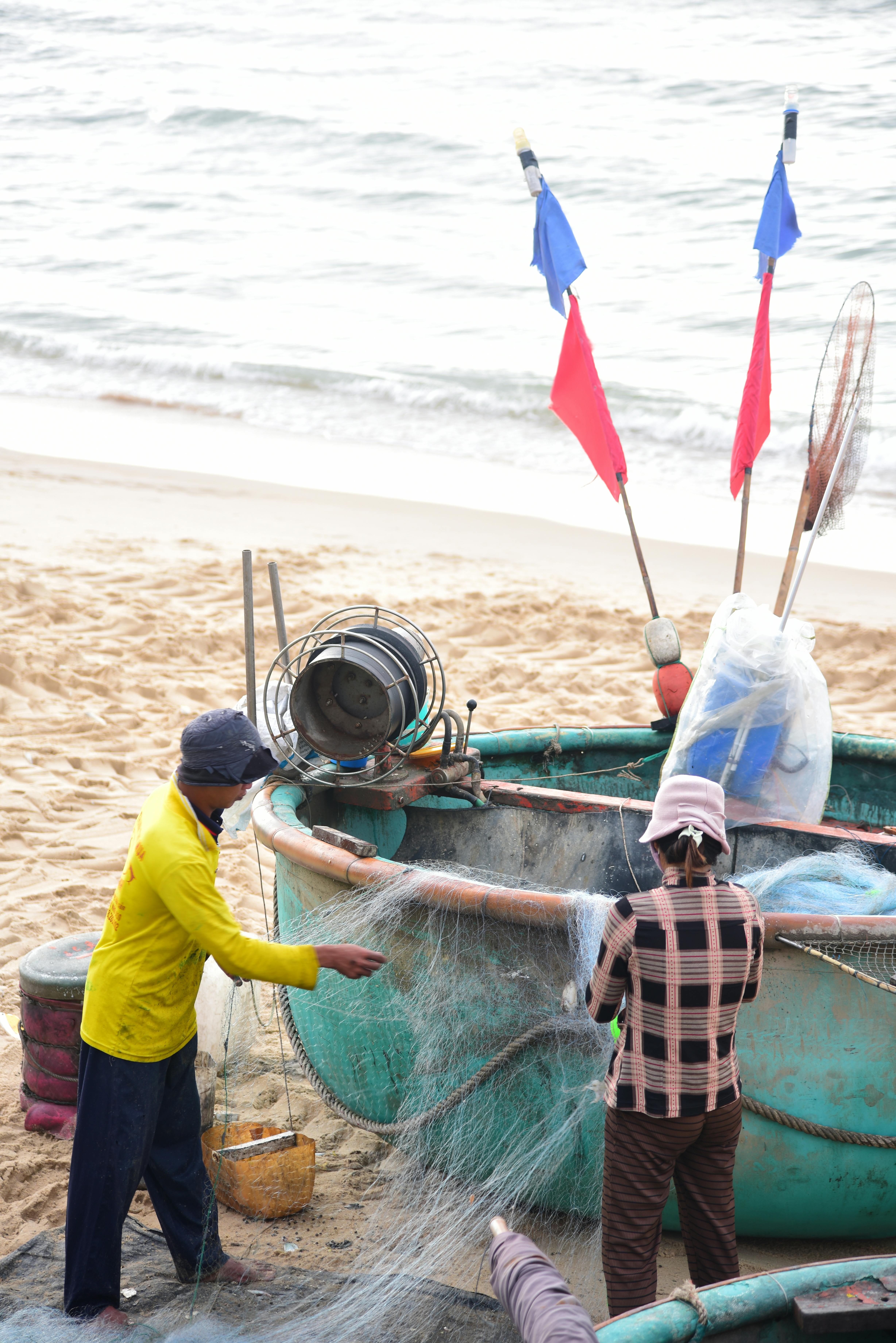 Fishermen Preparing Nets on the Beach · Free Stock Photo