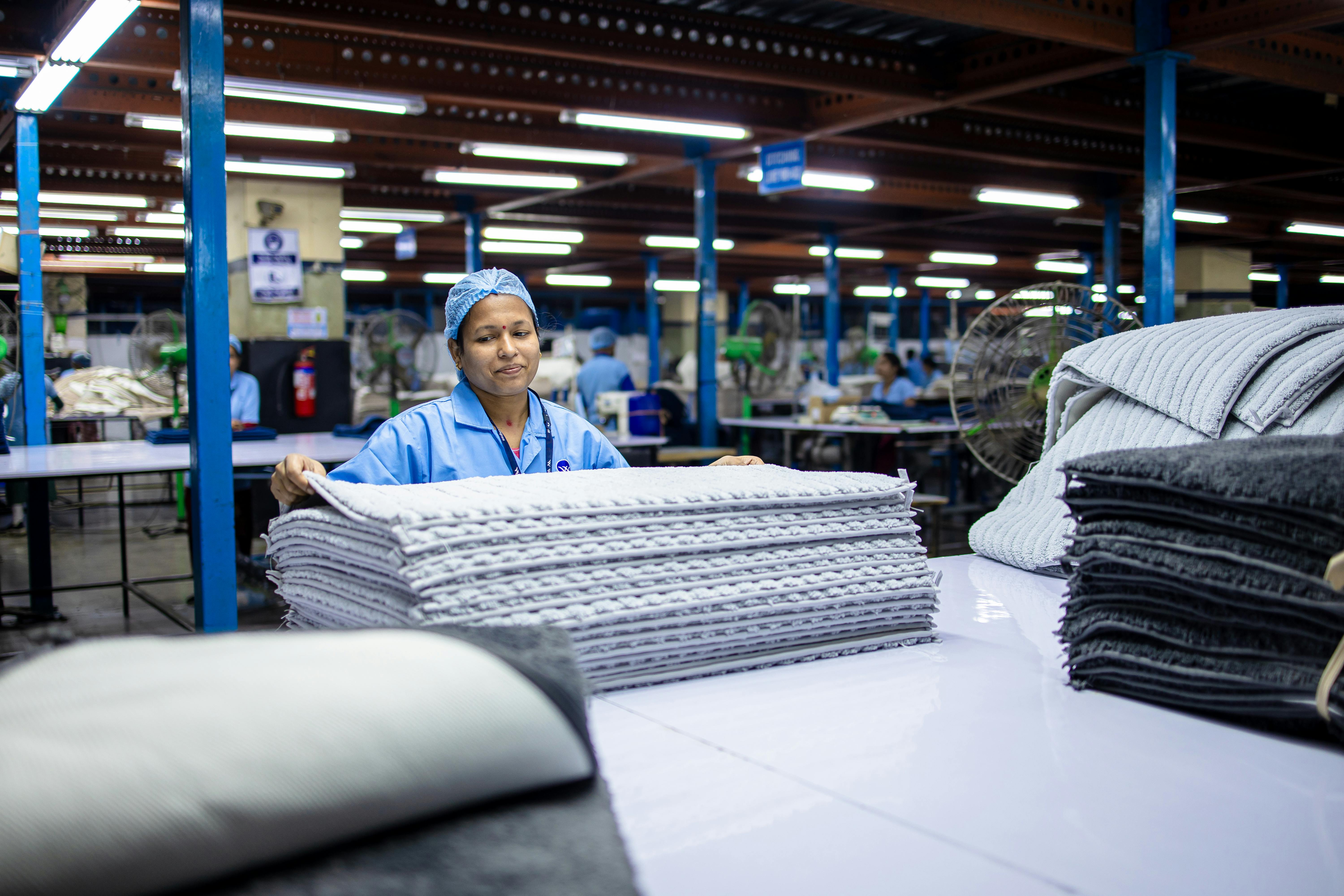 Textile Factory Worker Organizing Fabrics · Free Stock Photo