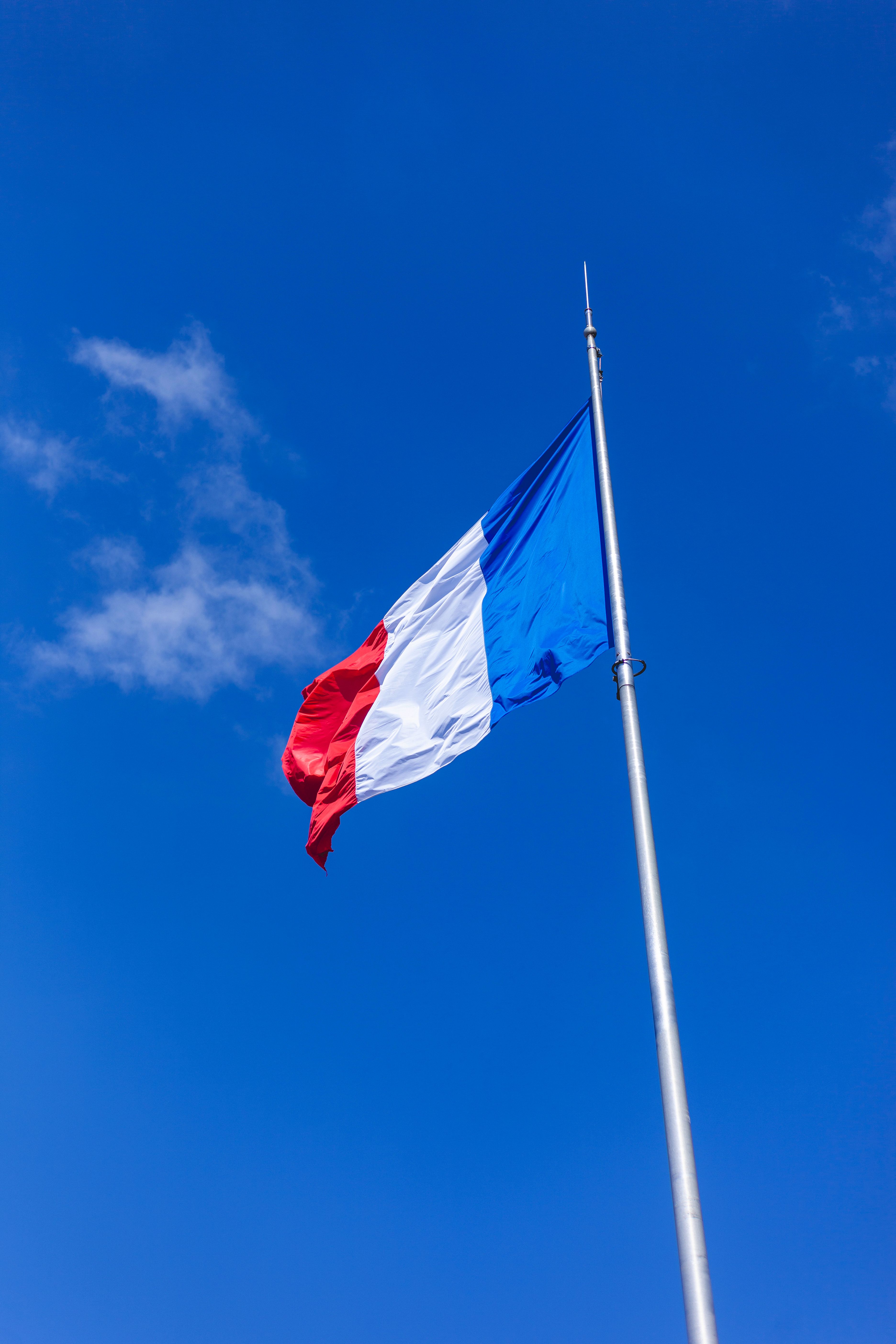 Bandera Francesa Ondeando En Un Cielo Azul Claro · Foto de stock gratuita