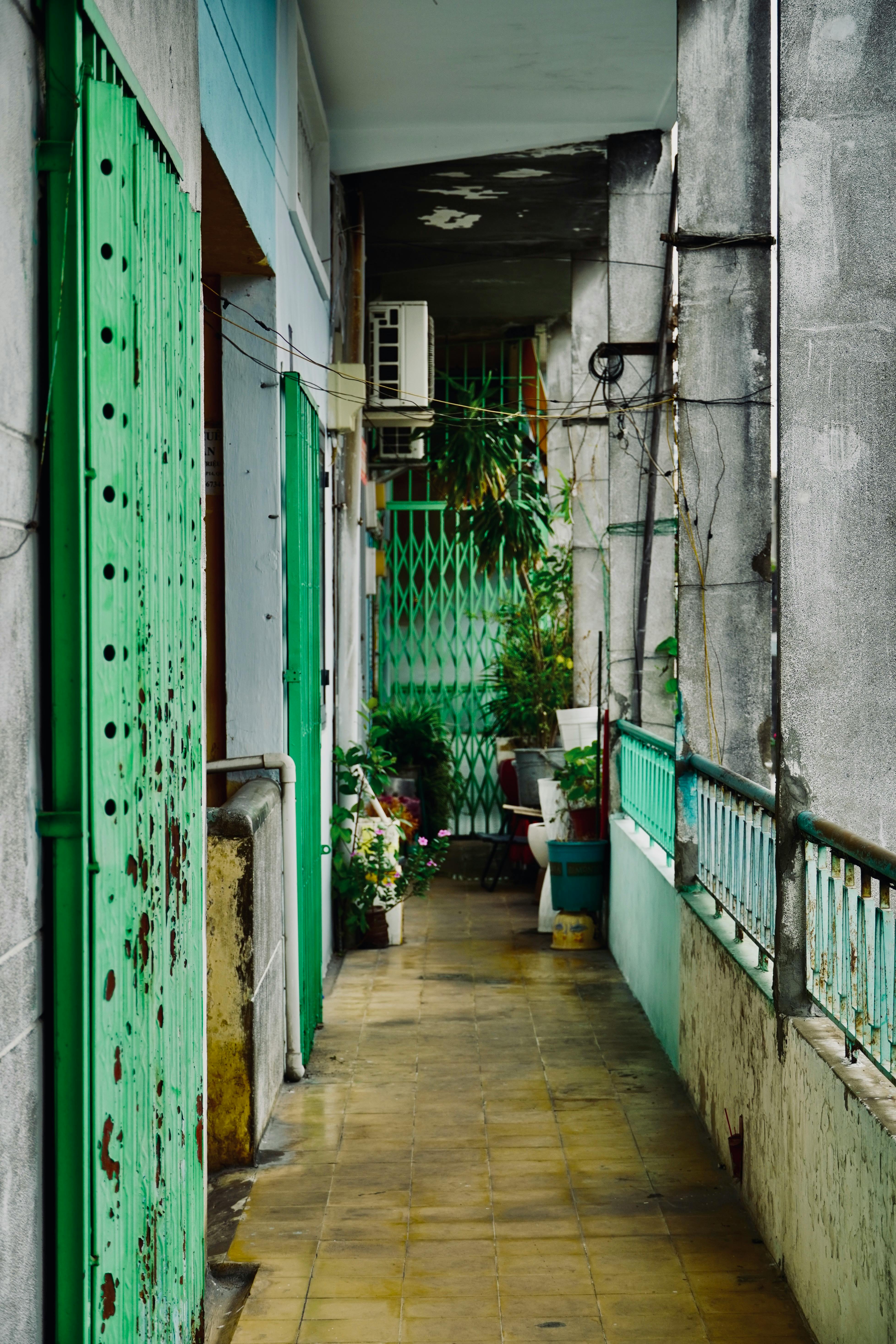Rustic Balcony Corridor with Green Doors · Free Stock Photo