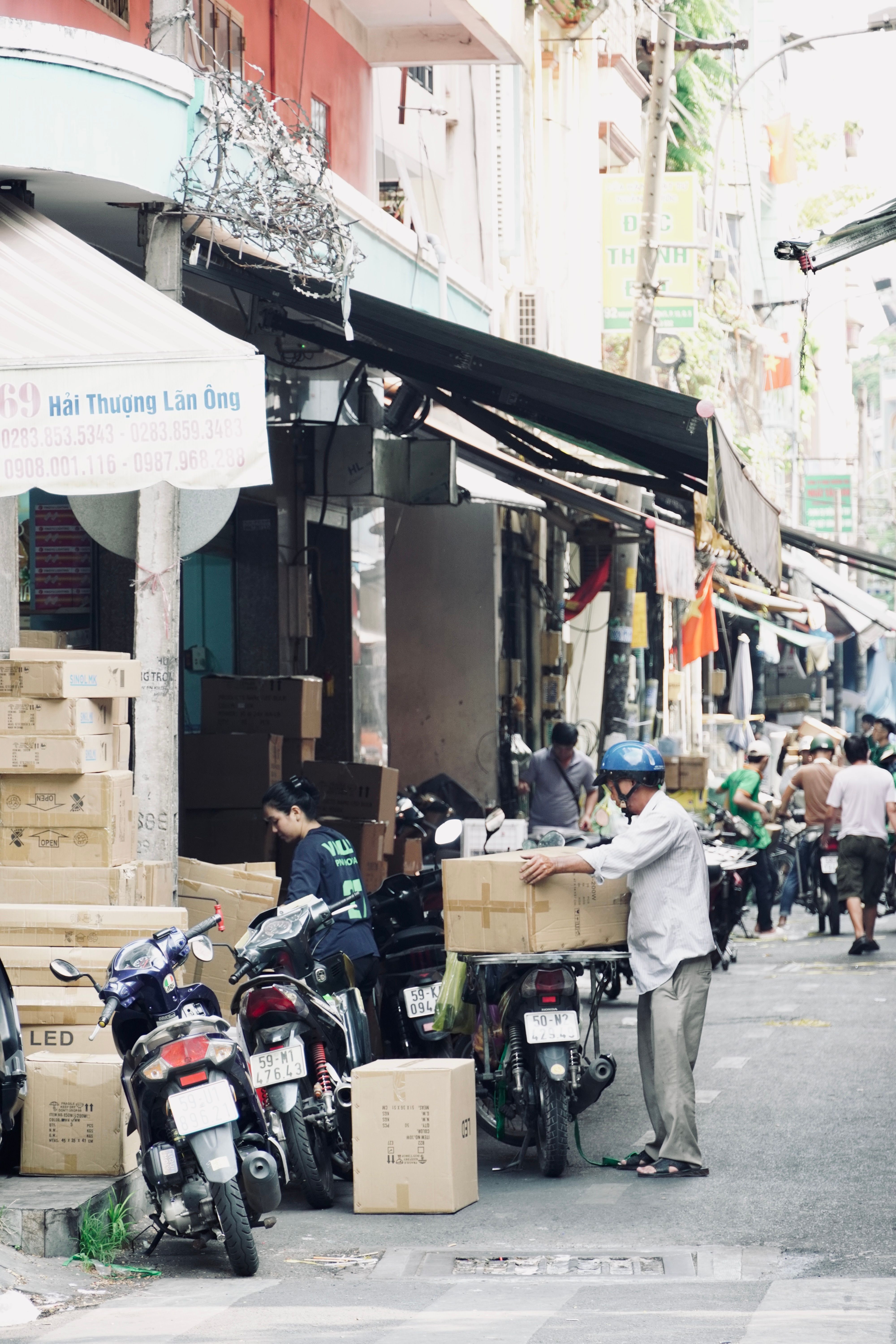 Bustling Street with Motorcycles and Deliveries · Free Stock Photo