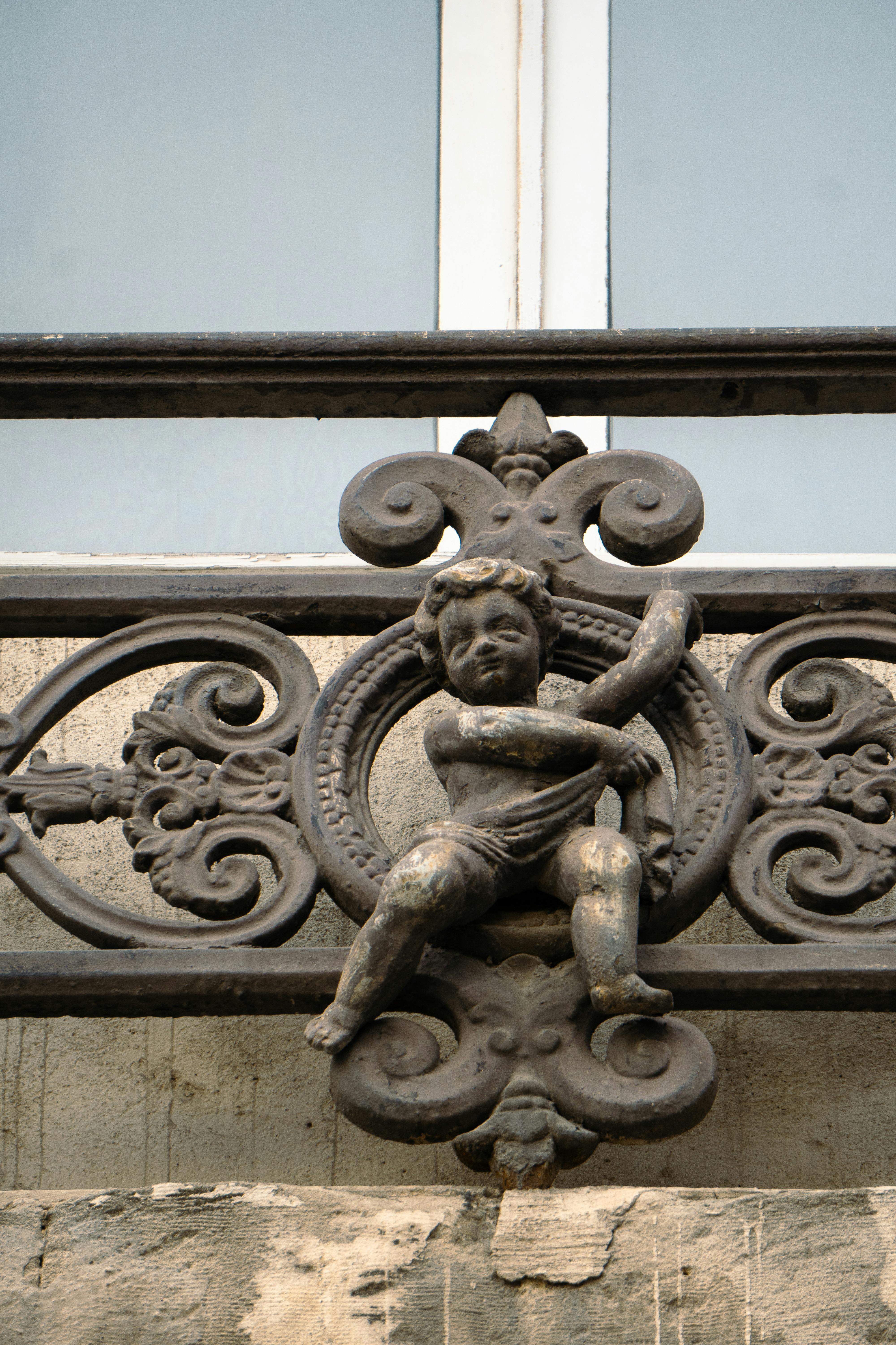 Ornate Cast Iron Sculpture on Building Facade · Free Stock Photo