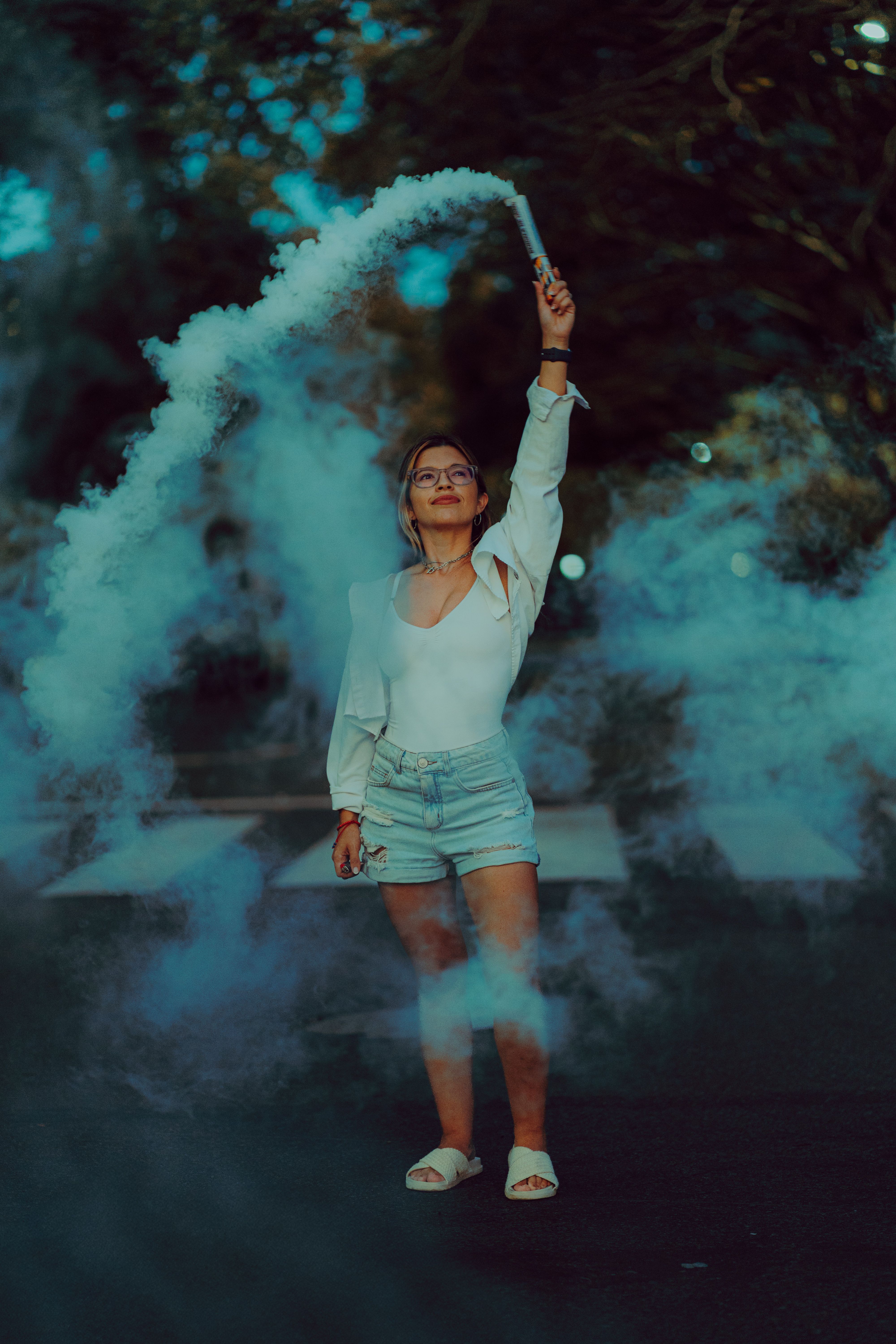 Woman Celebrating with Blue Smoke Outdoors · Free Stock Photo