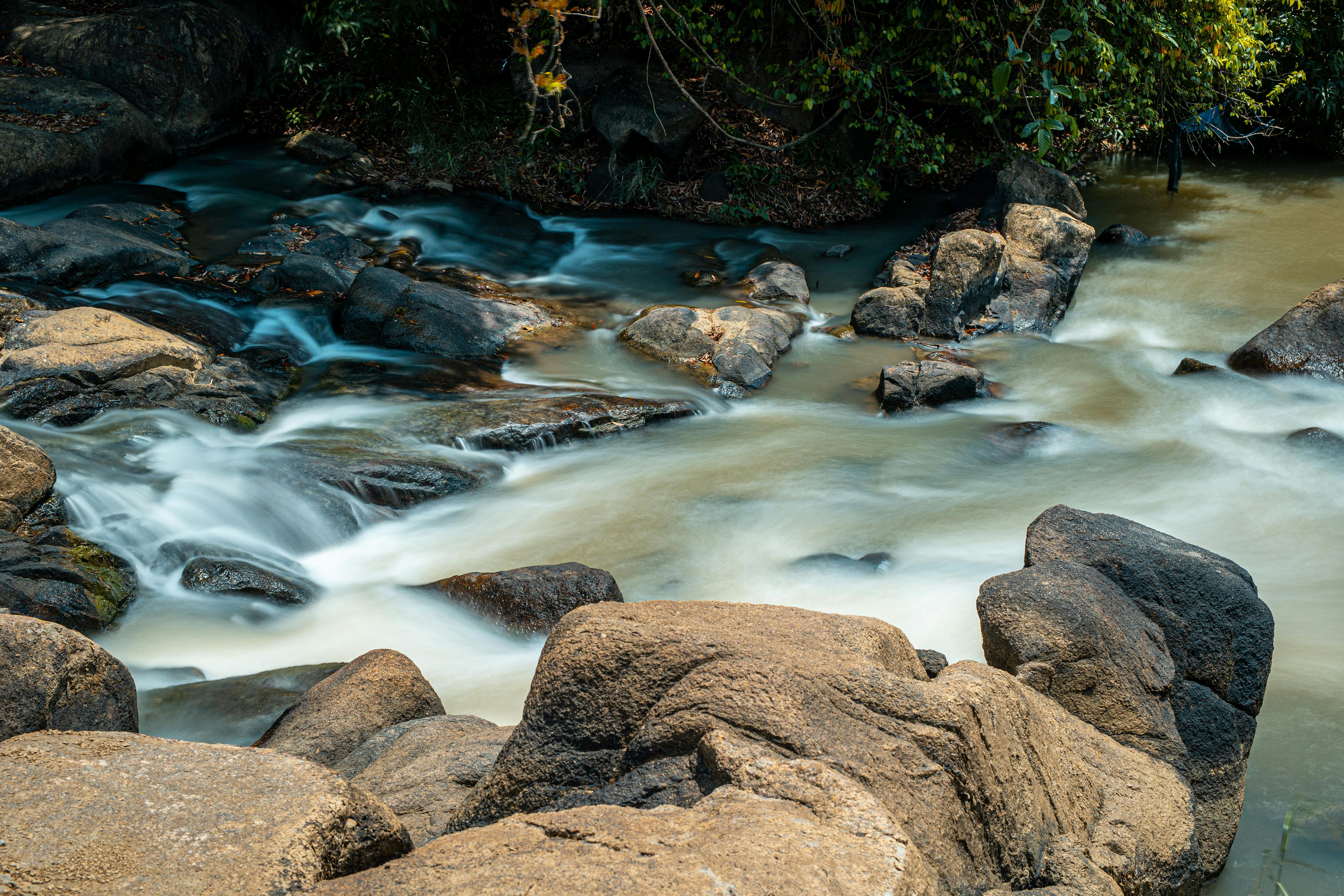 Peaceful River Flow Over Rocks in Natural Setting · Free Stock Photo