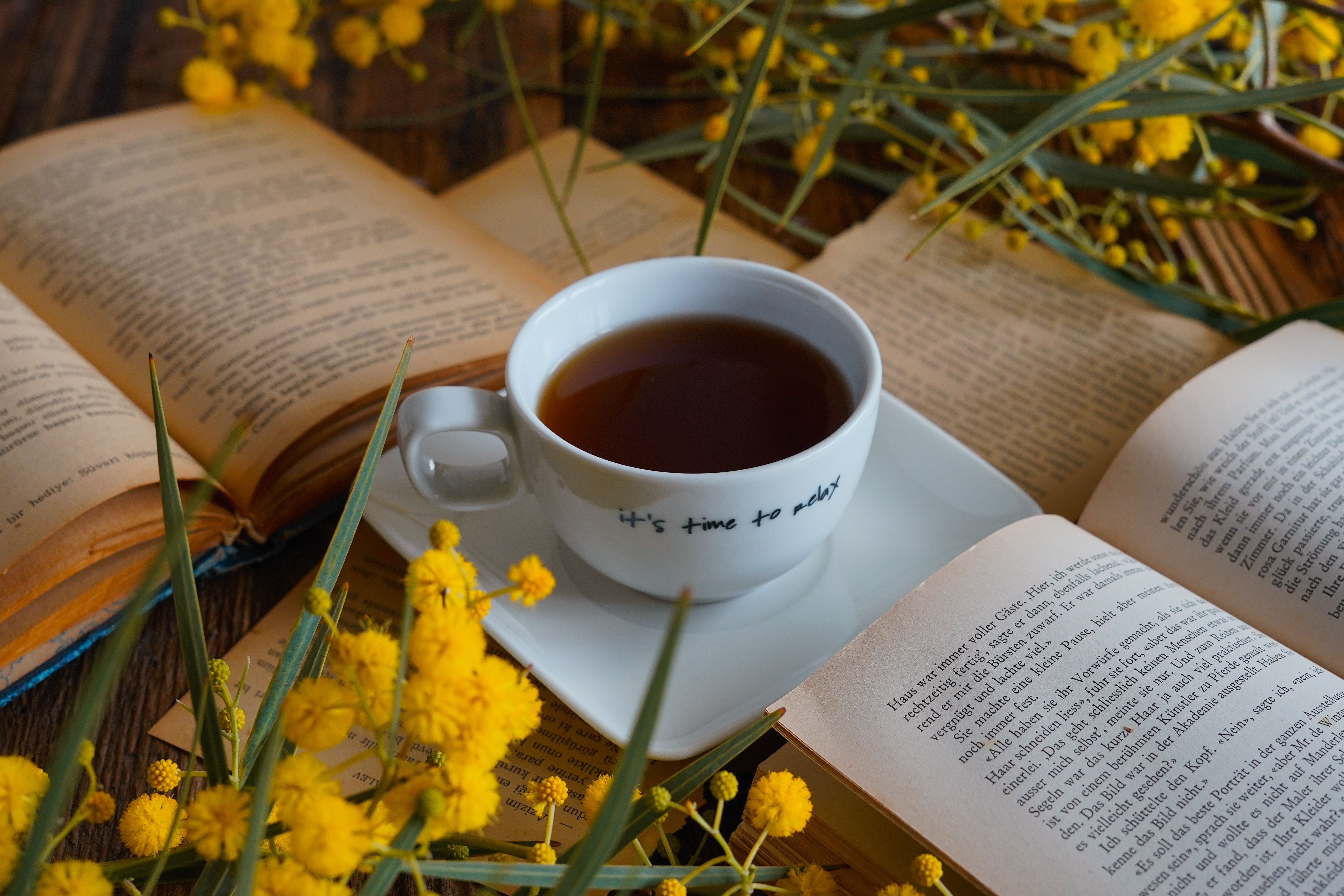Cozy Reading Moment with Tea and Yellow Flowers · Free Stock Photo