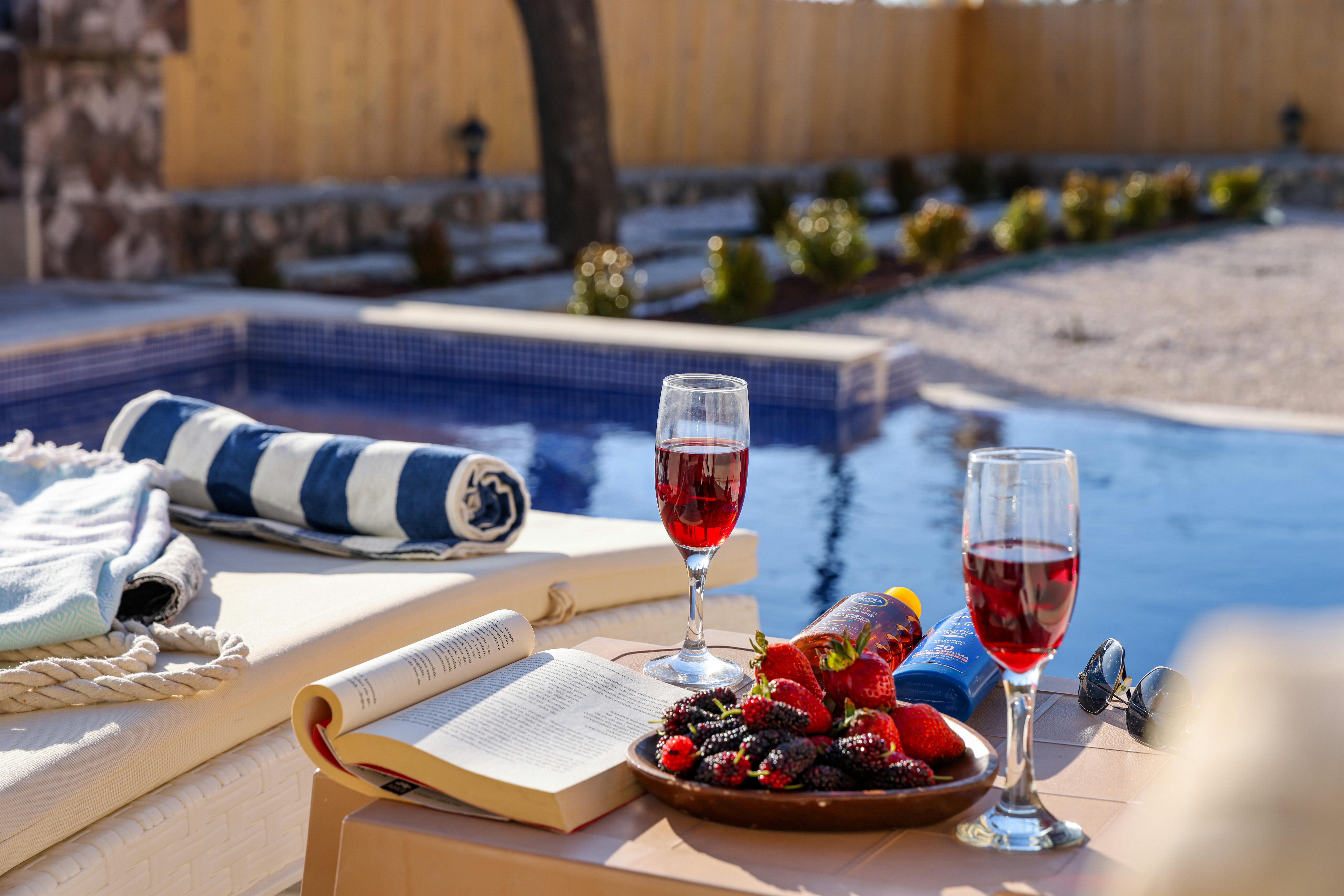 Relaxing Poolside Scene with Wine and Berries · Free Stock Photo