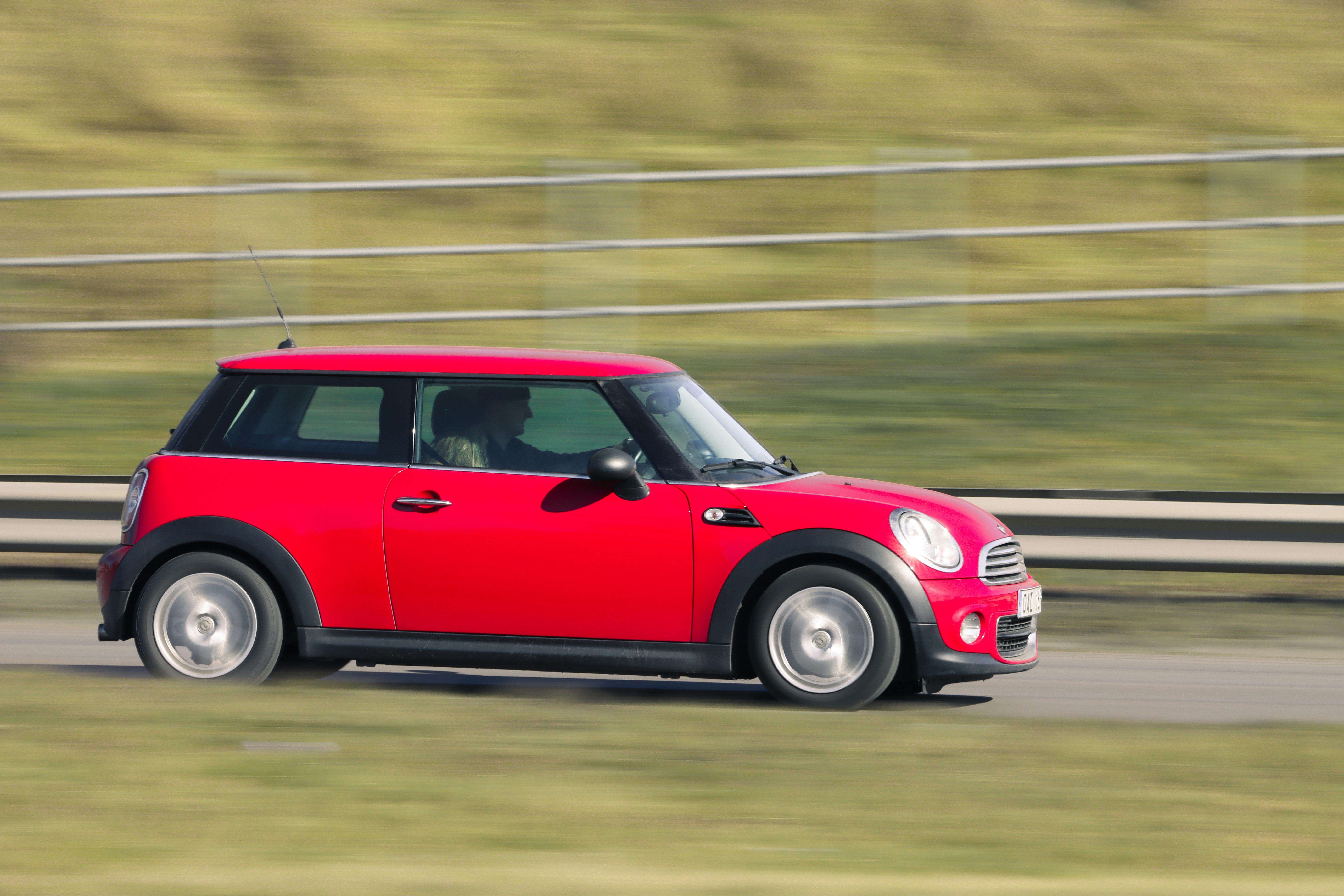 Sleek Mini Cooper Driving on Scenic Roadway · Free Stock Photo