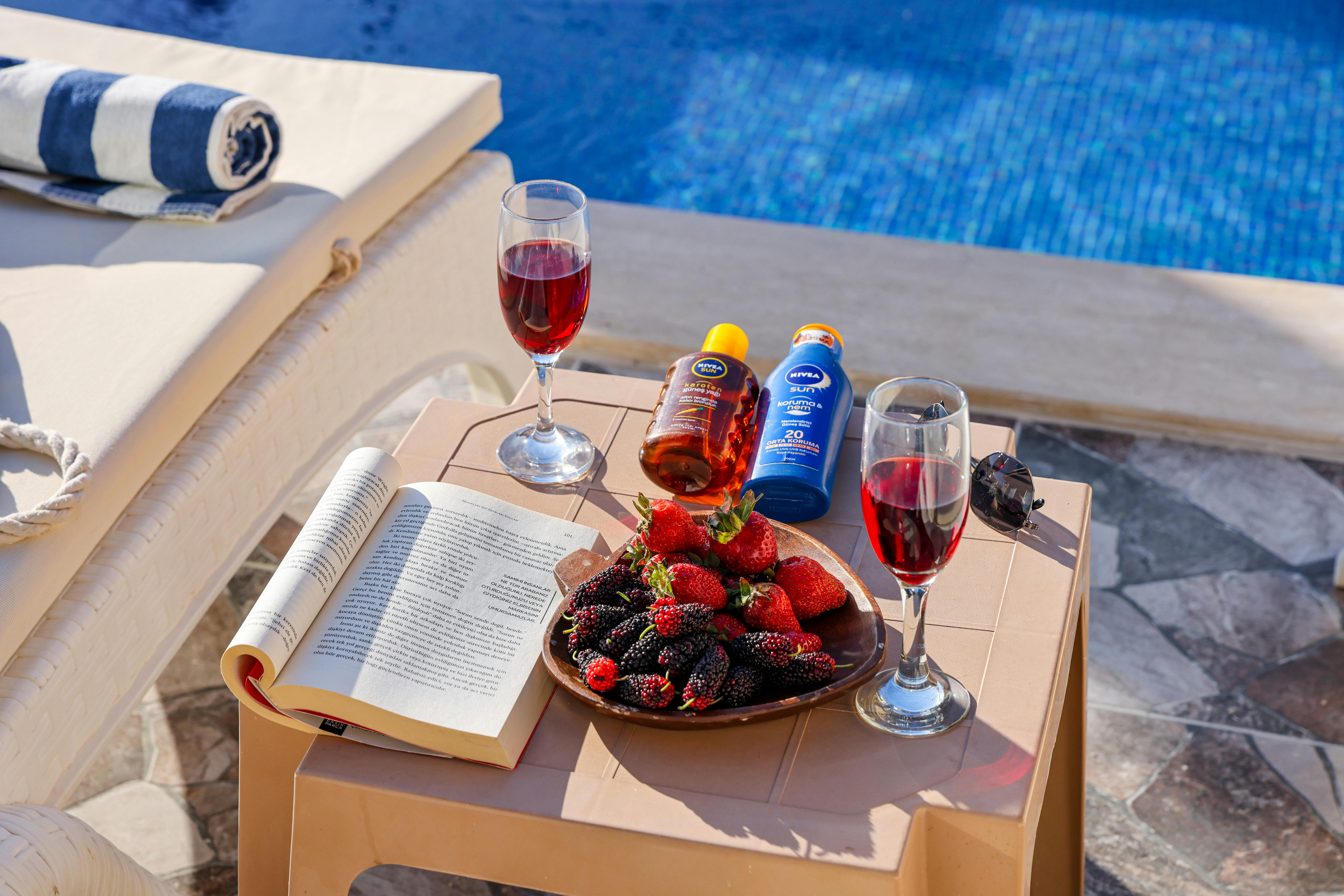 Elegant Poolside Setup with Fruits and Wine · Free Stock Photo