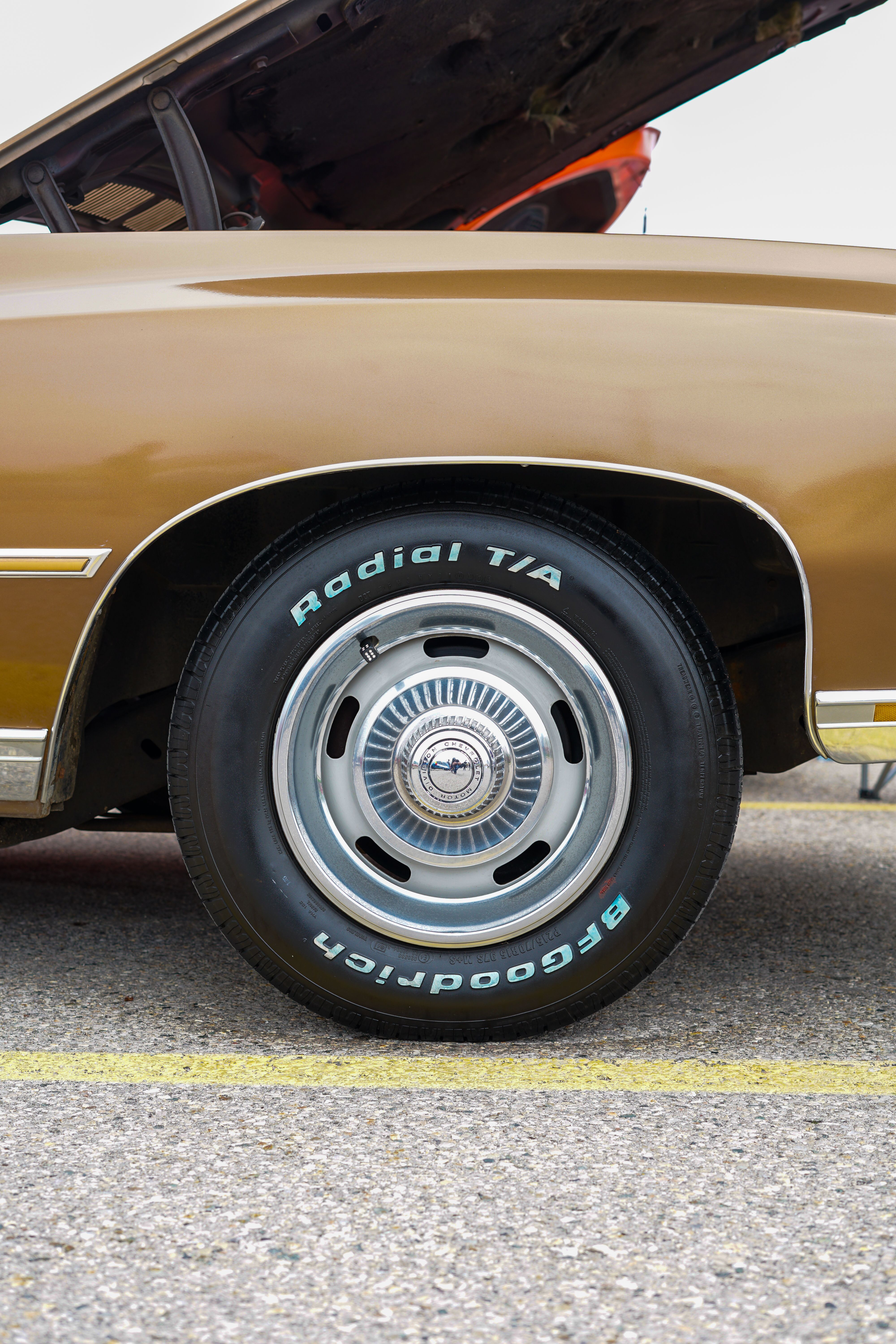 Close-Up of Vintage Car Tire with Open Hood · Free Stock Photo