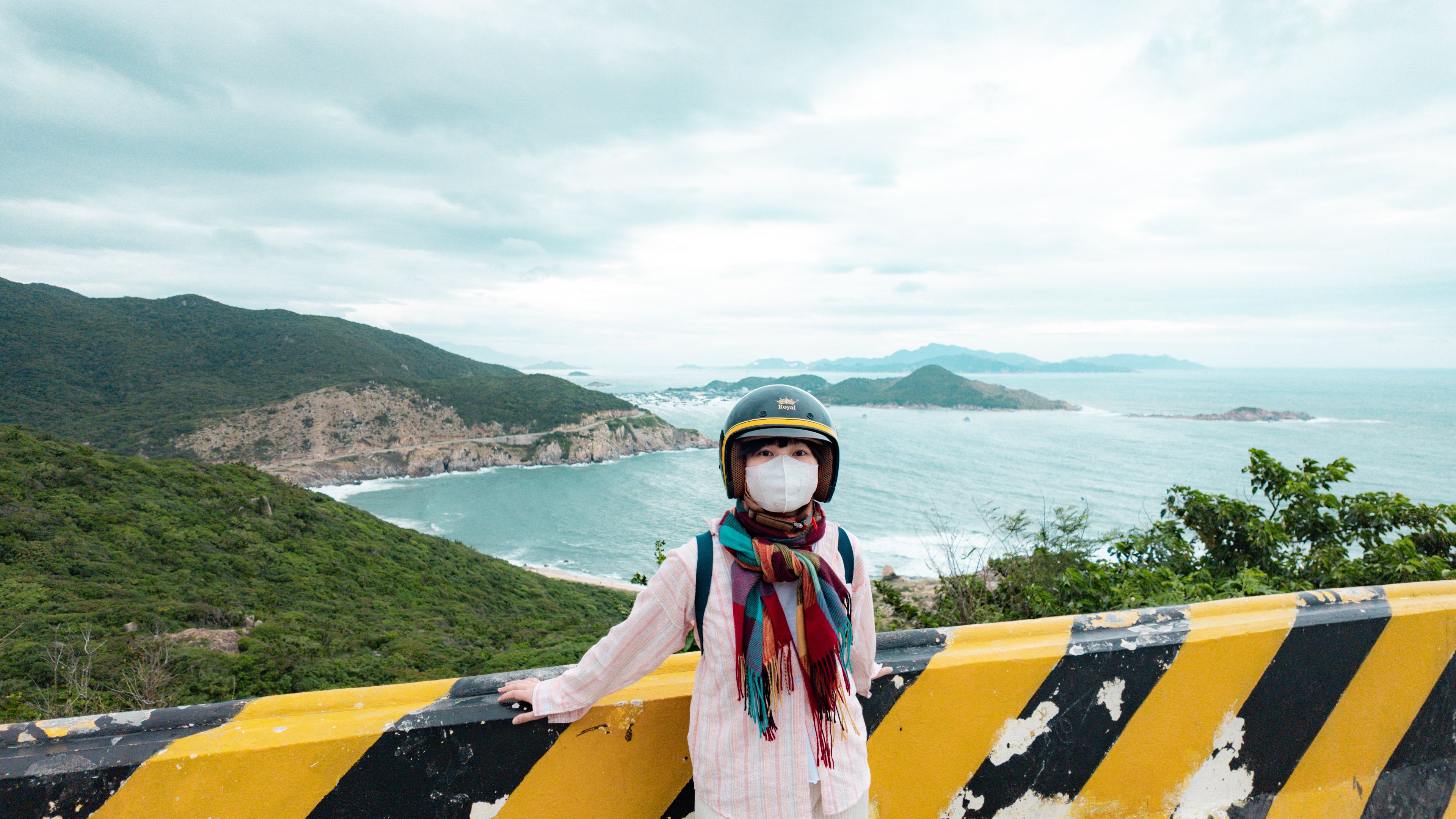 Traveler with Mask at Scenic Coastal Viewpoint · Free Stock Photo