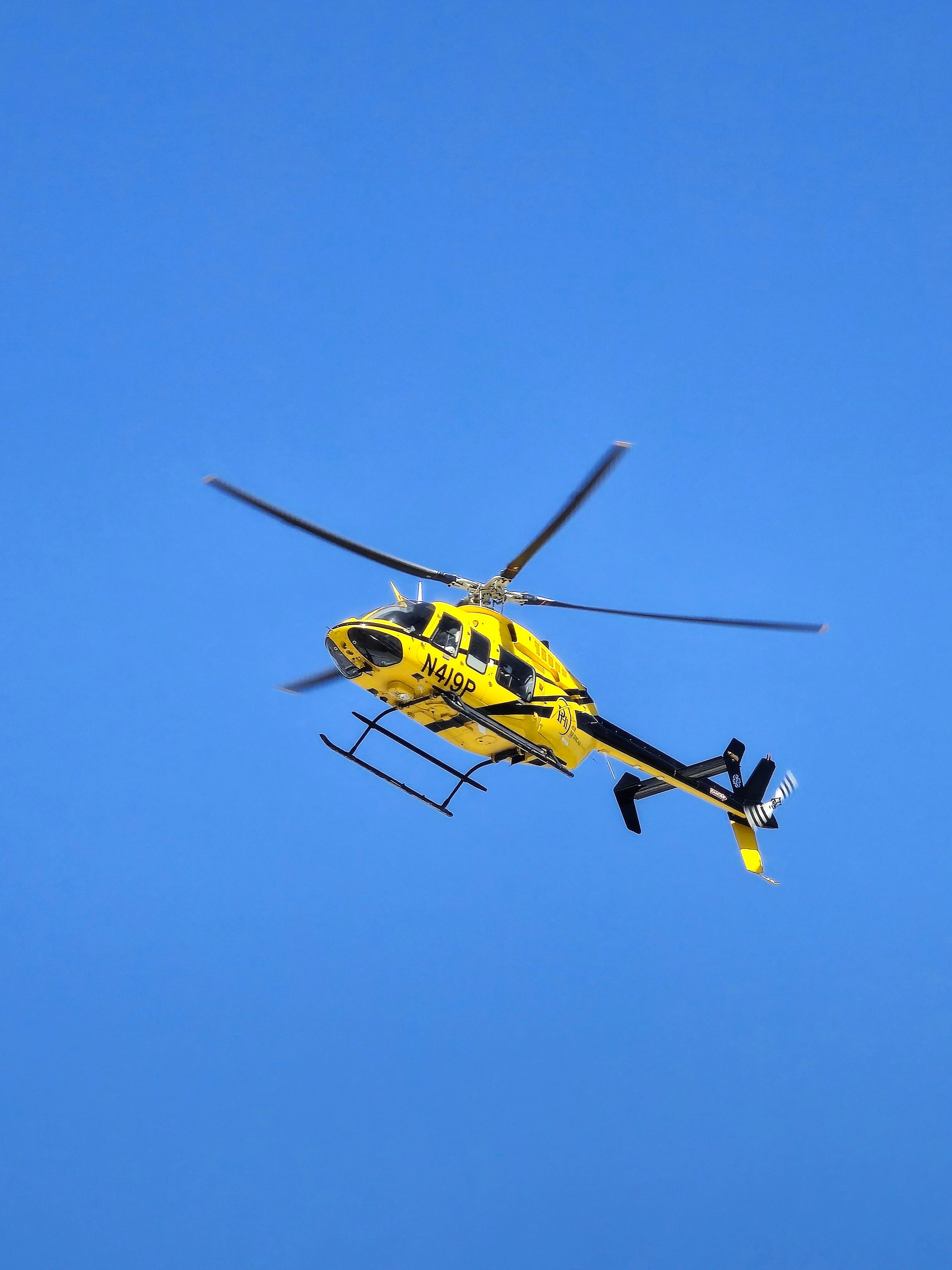 Bright Yellow Helicopter in Clear Blue Sky · Free Stock Photo