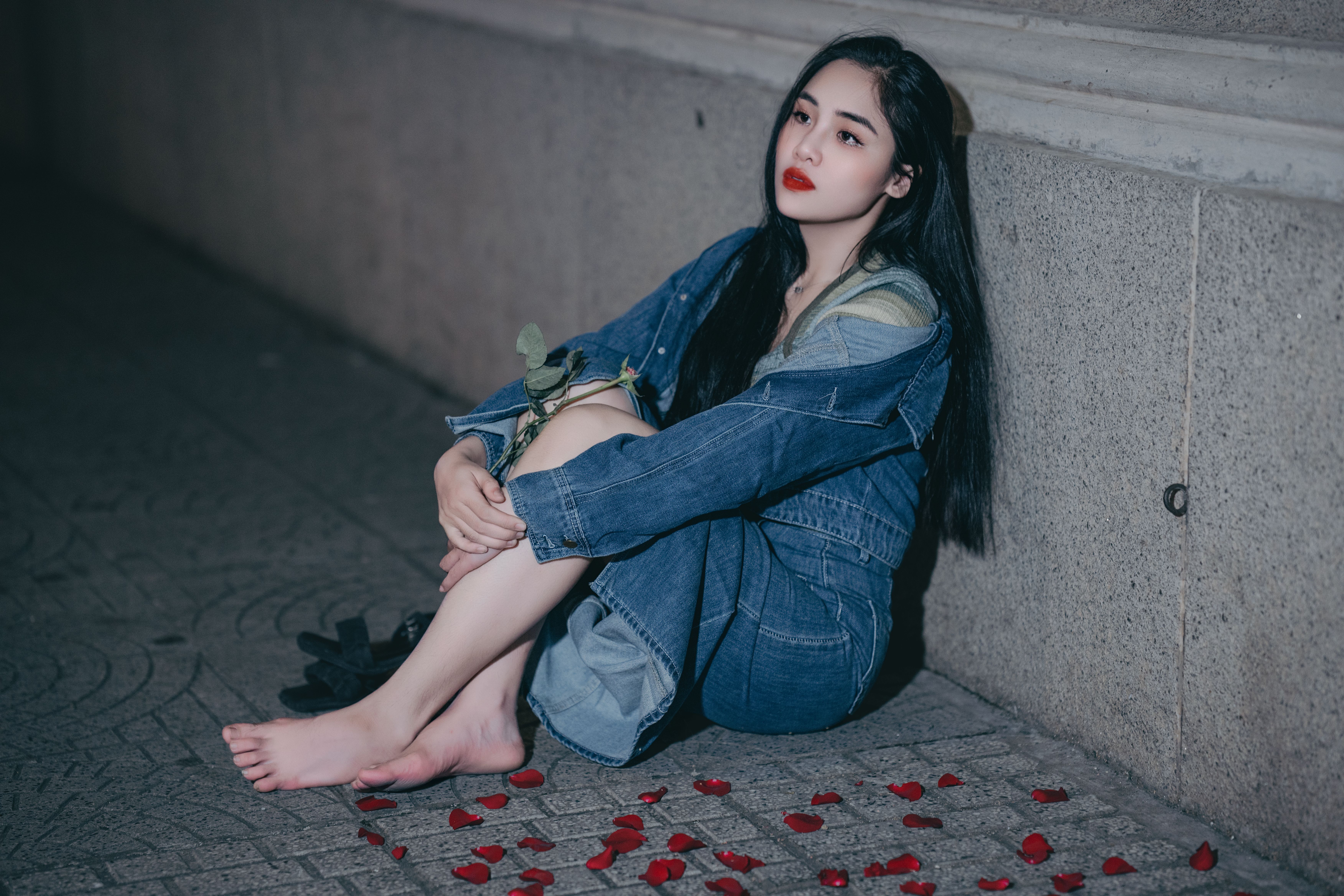 Contemplative Woman in Denim Sitting with Roses · Free Stock Photo