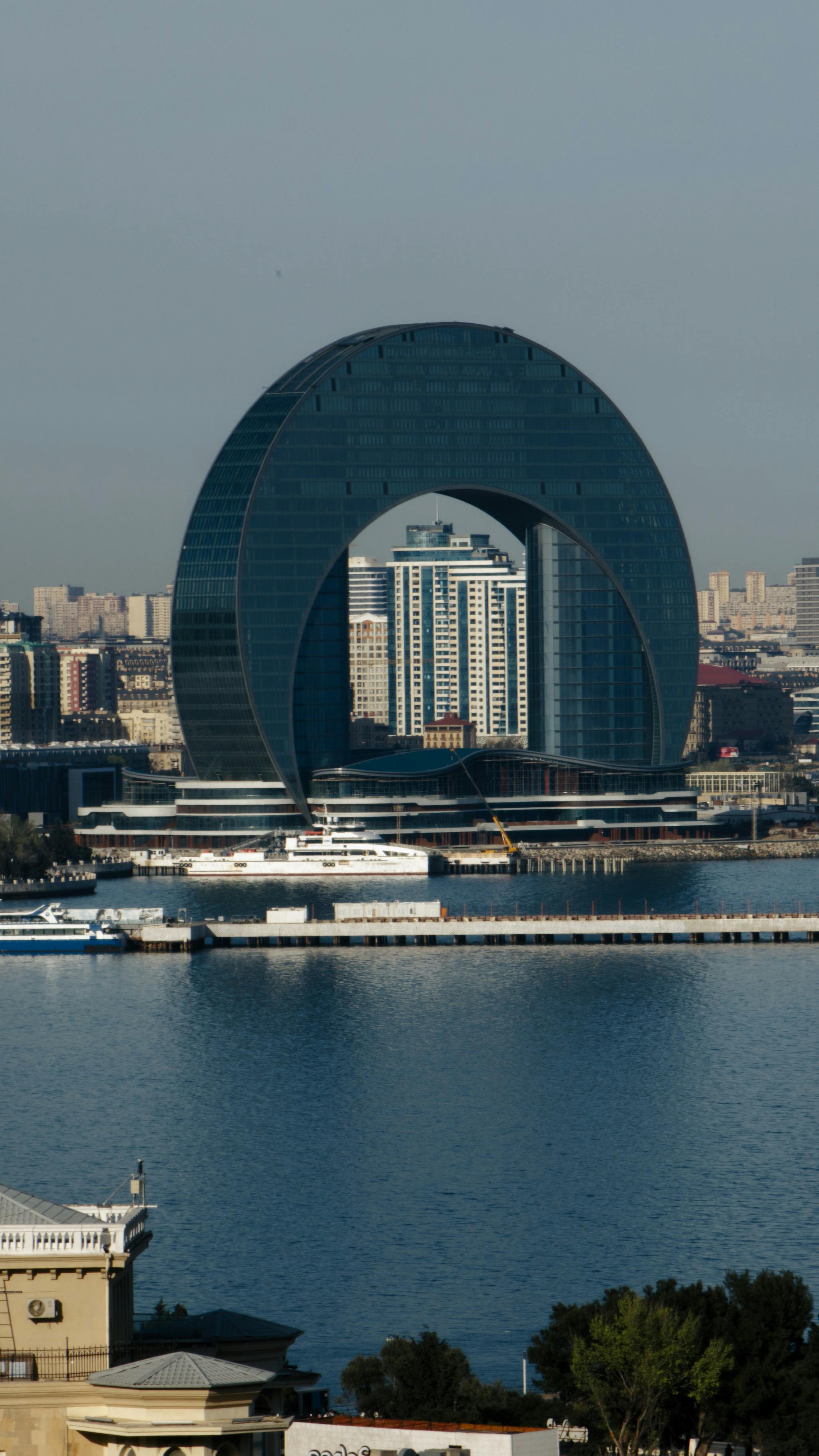 Modern Arc Shaped Building by Waterfront · Free Stock Photo