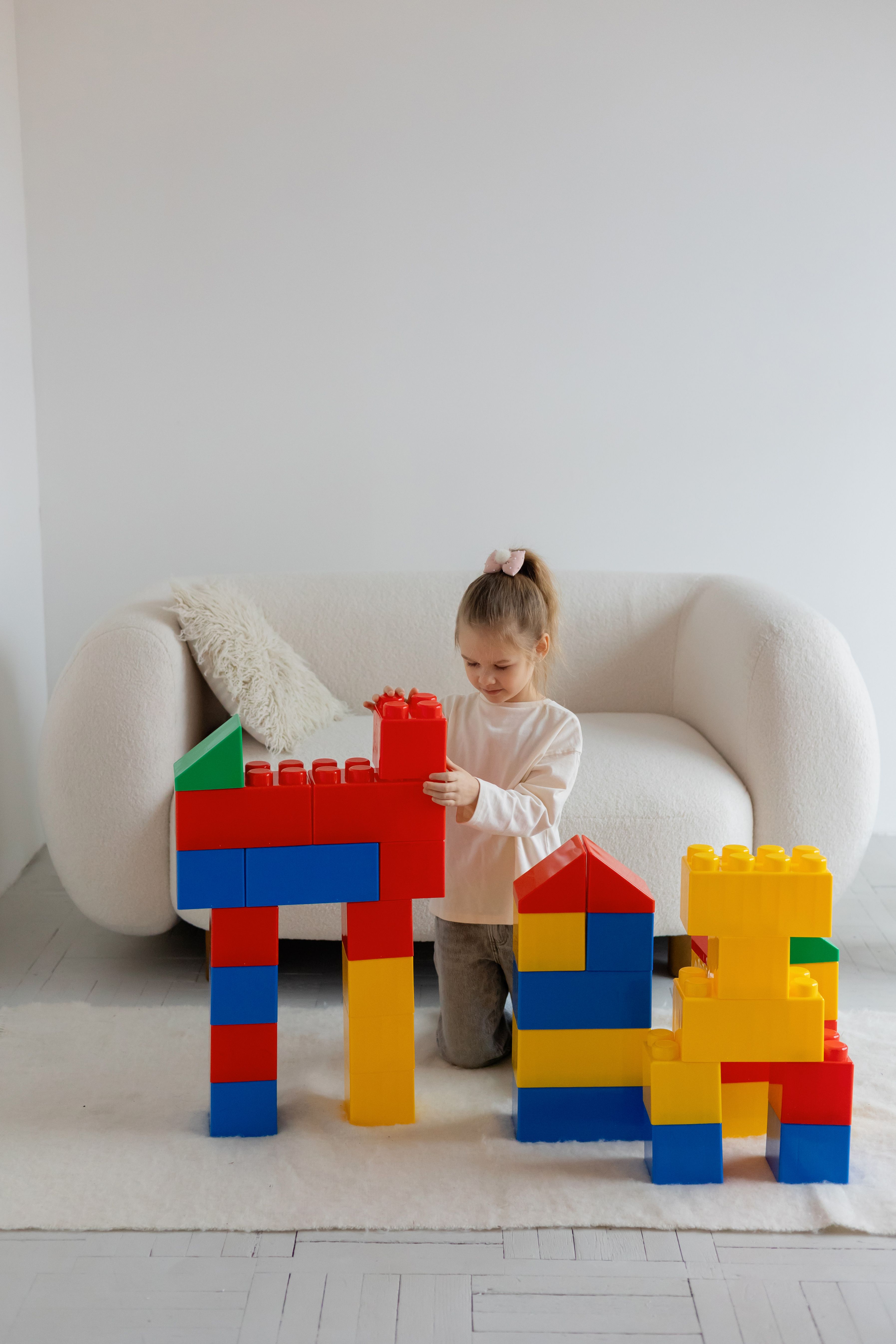 Young Girl Building with Colorful Toy Blocks Indoors · Free Stock Photo