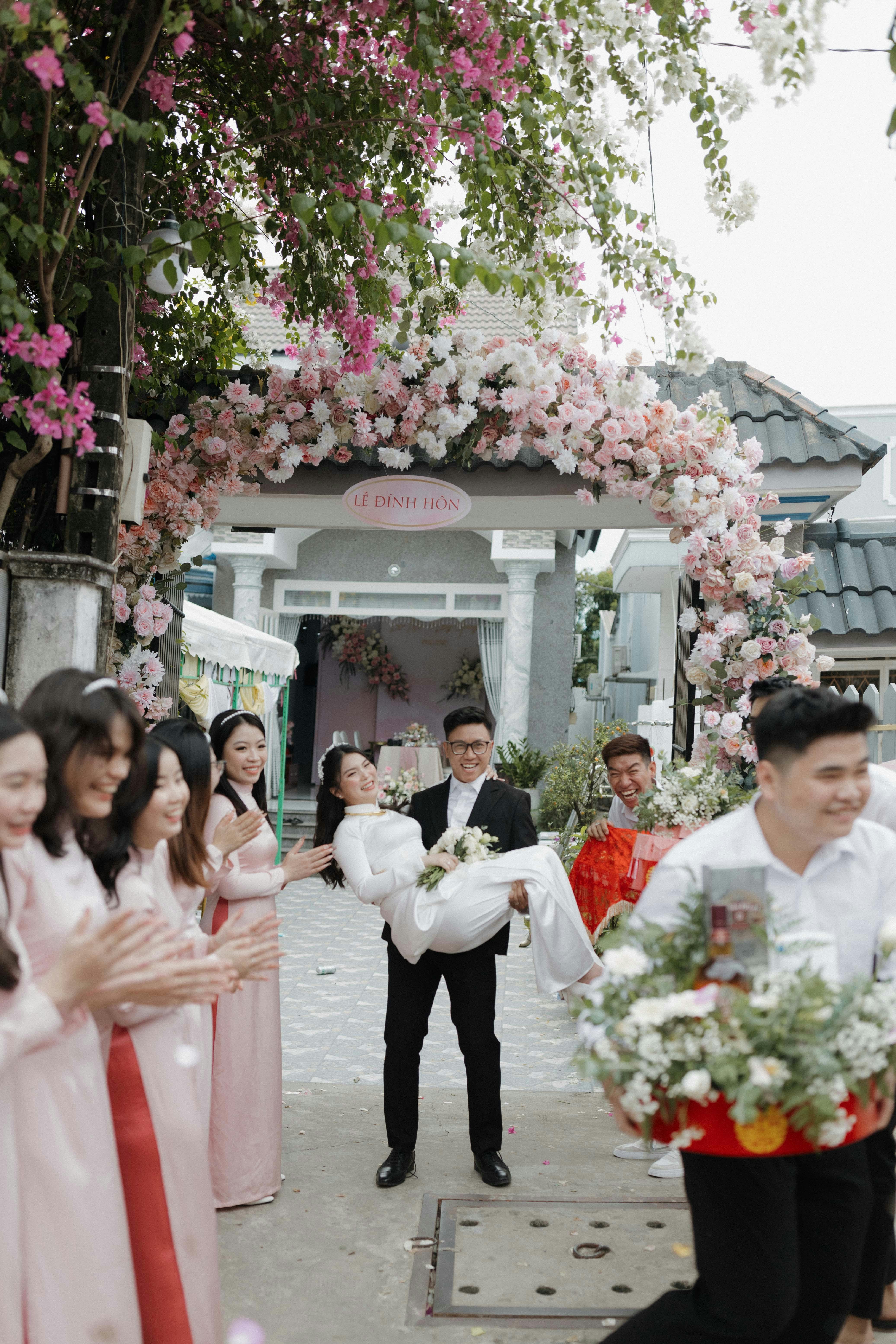 Joyful Wedding Procession Under Floral Arch · Free Stock Photo