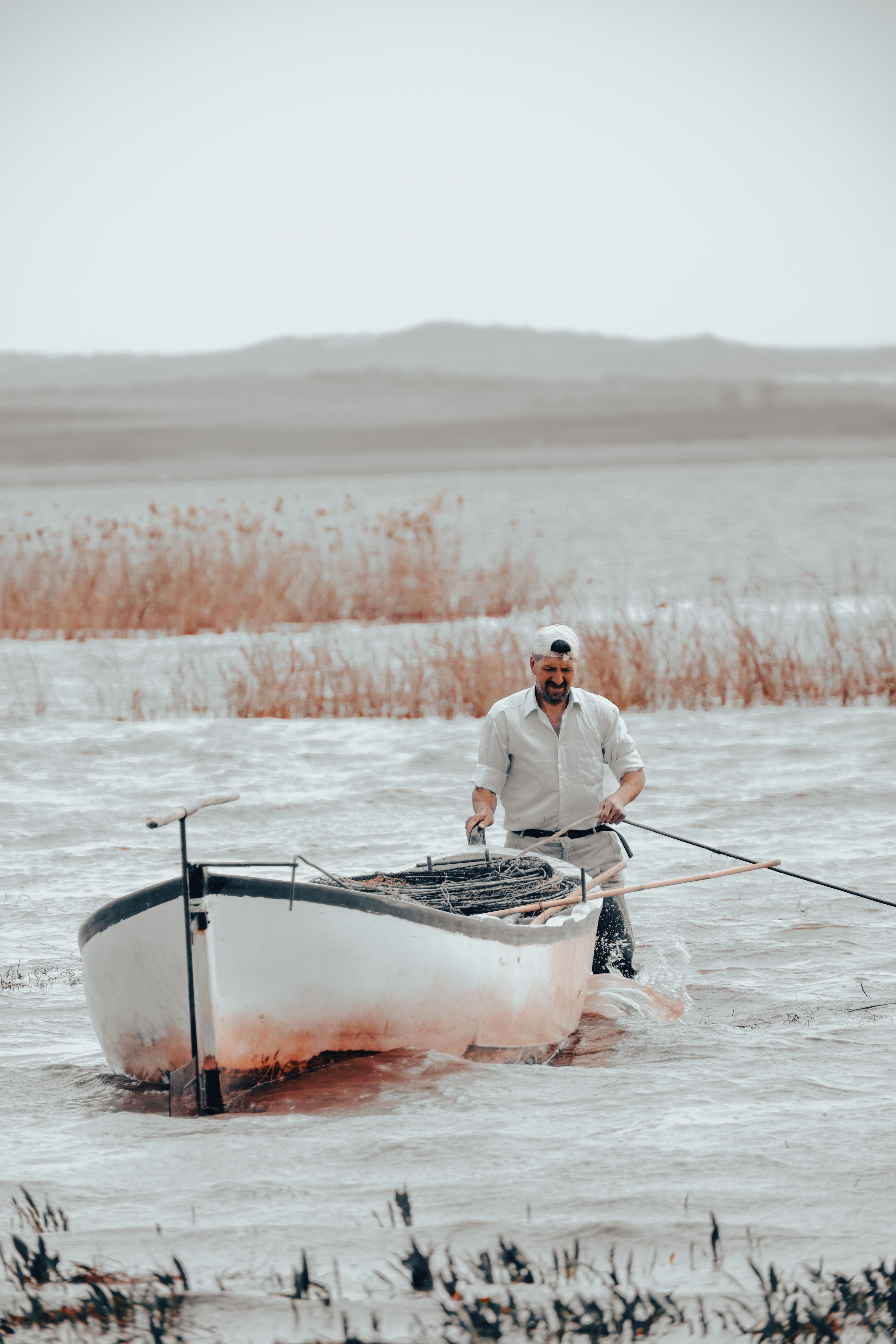 Man Fishing from Boat in Calm Waters · Free Stock Photo